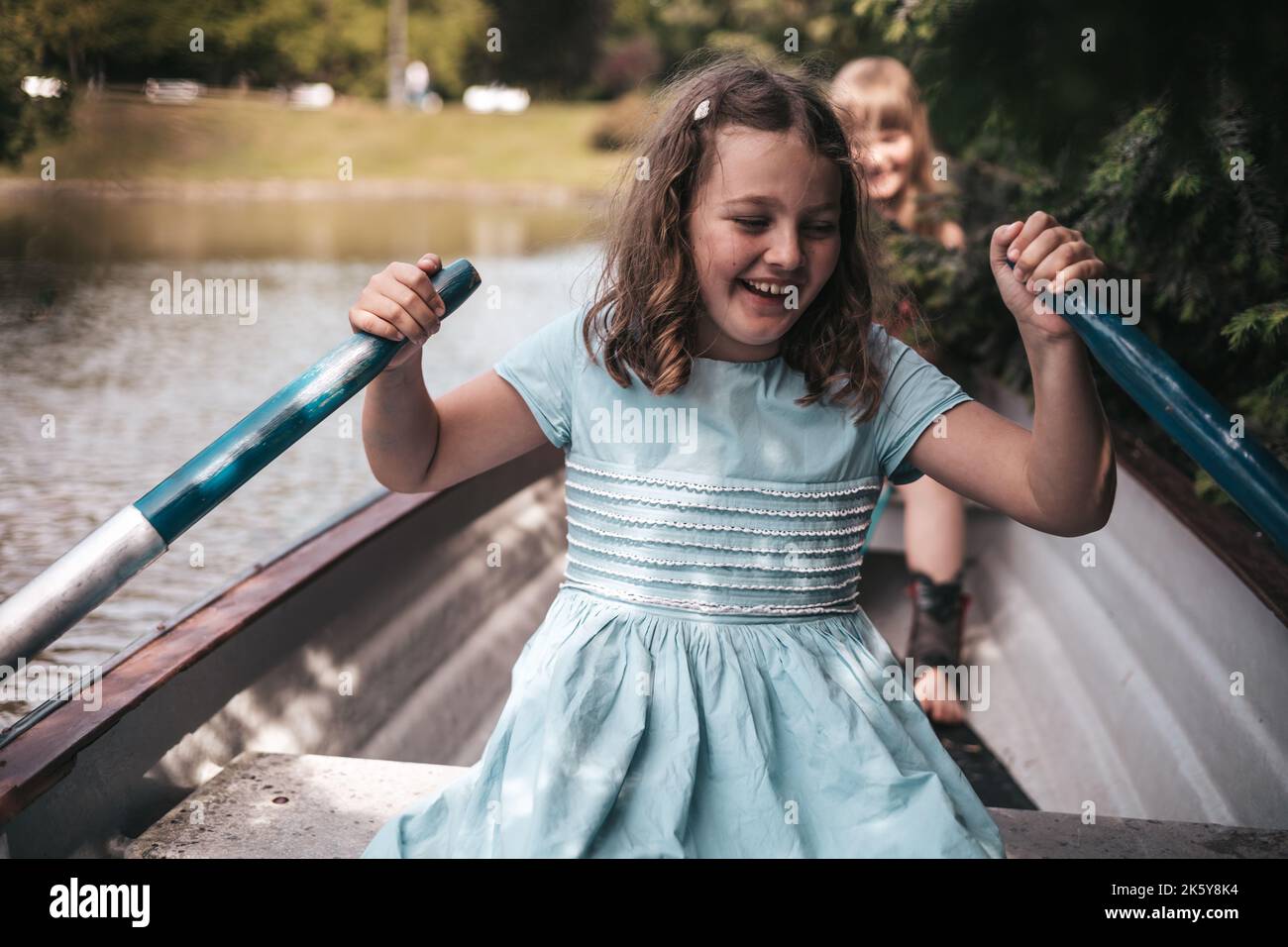 girl on a boat rowing oars, vacation in the village Stock Photo - Alamy