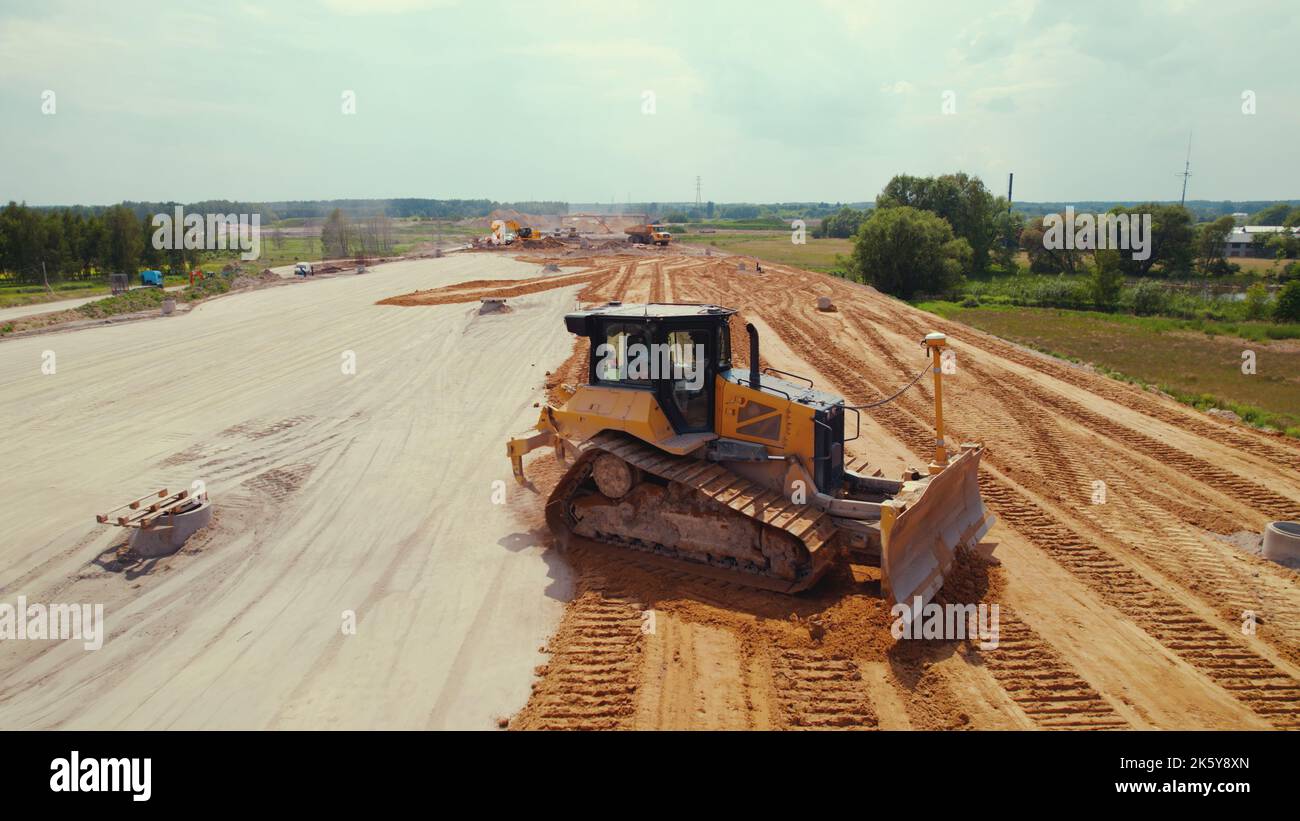 Surface grating. A bulldozer, road construction machinery moves the ...