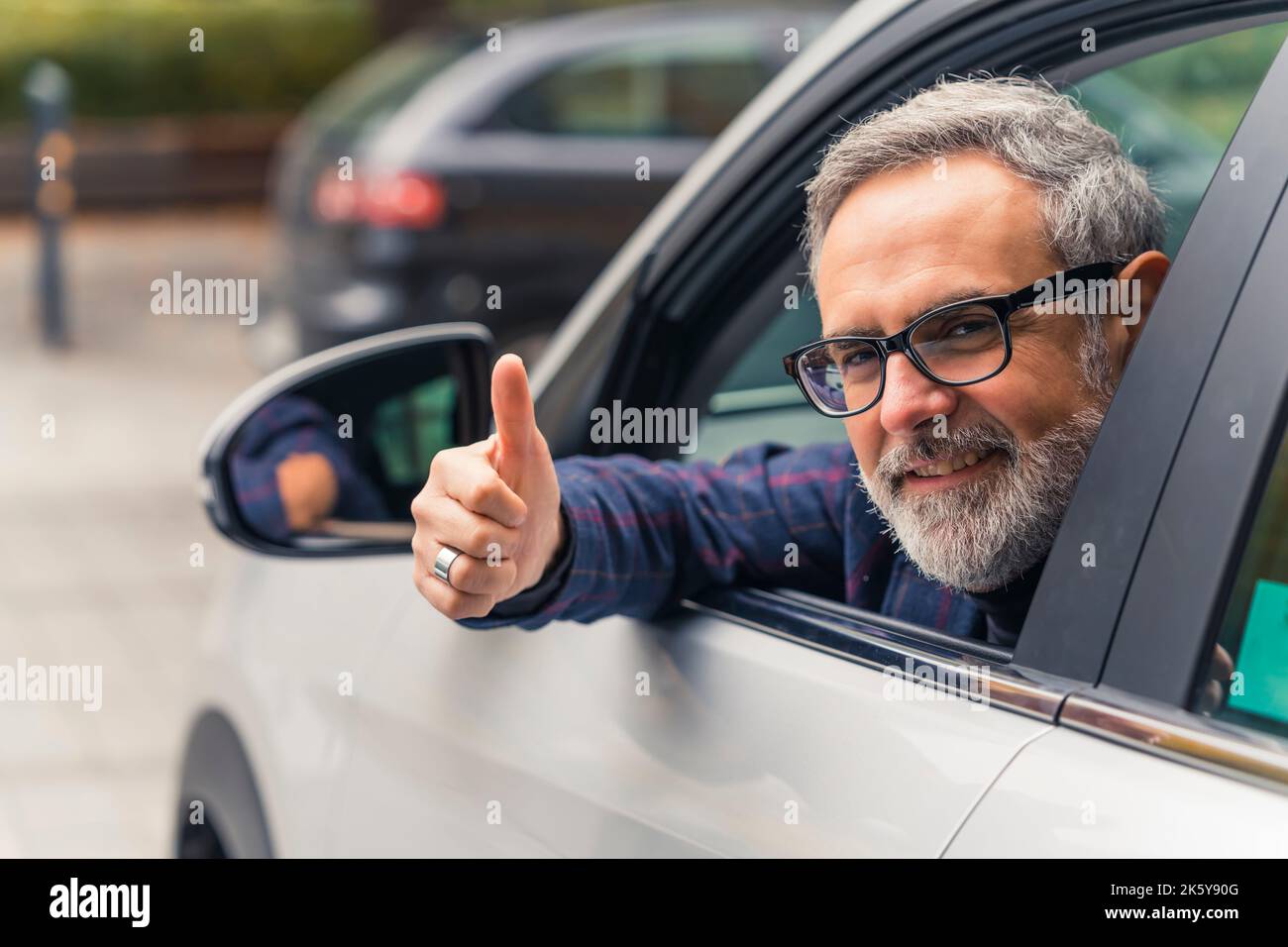 Man in suit leaning out of car window hi-res stock photography and ...