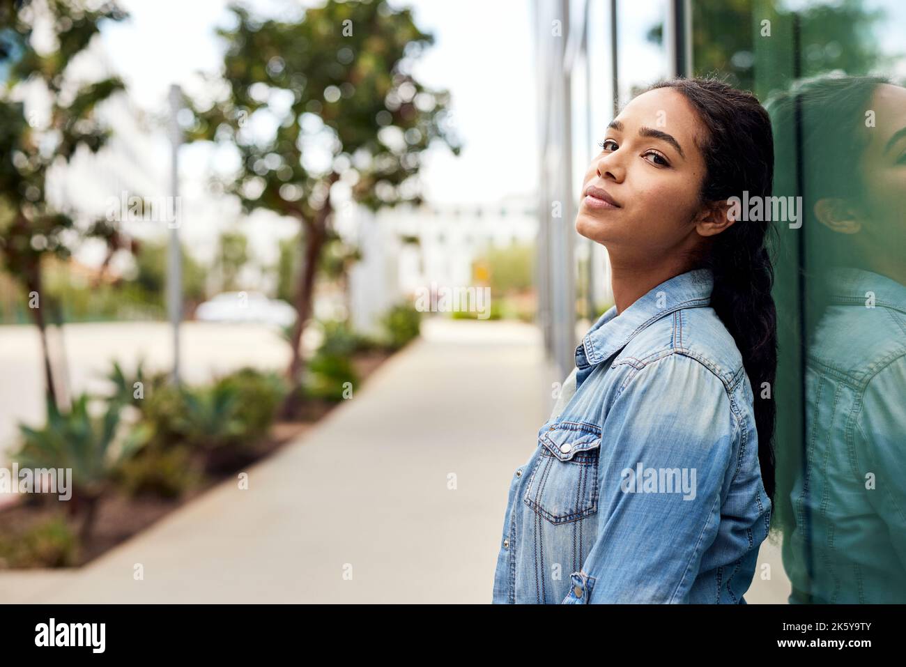 Side view portrait of woman leaning on wall Stock Photo - Alamy
