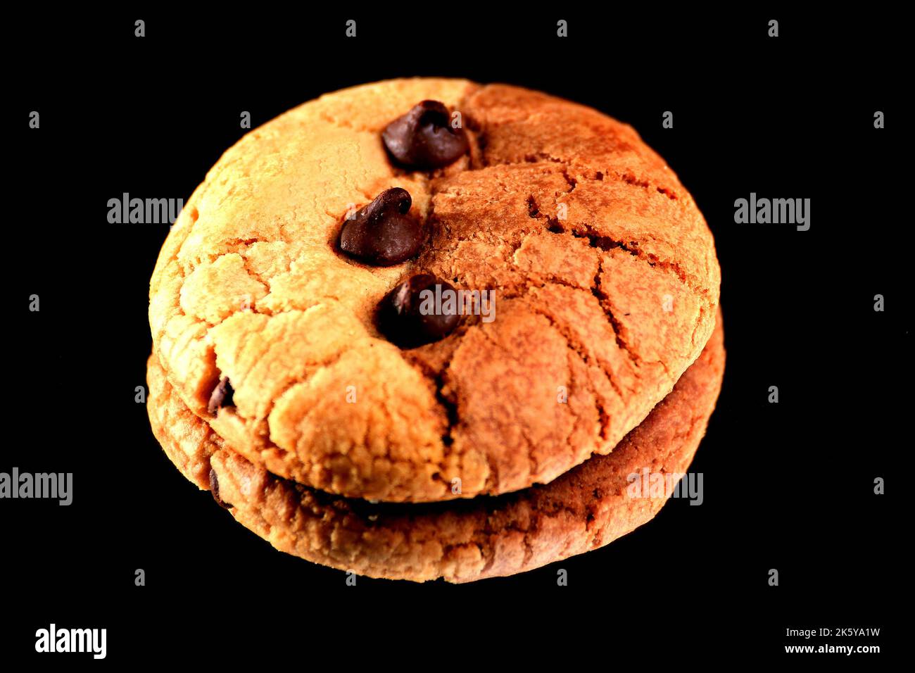 A closeup shot of a chocolate chip cookie isolated on a black ...