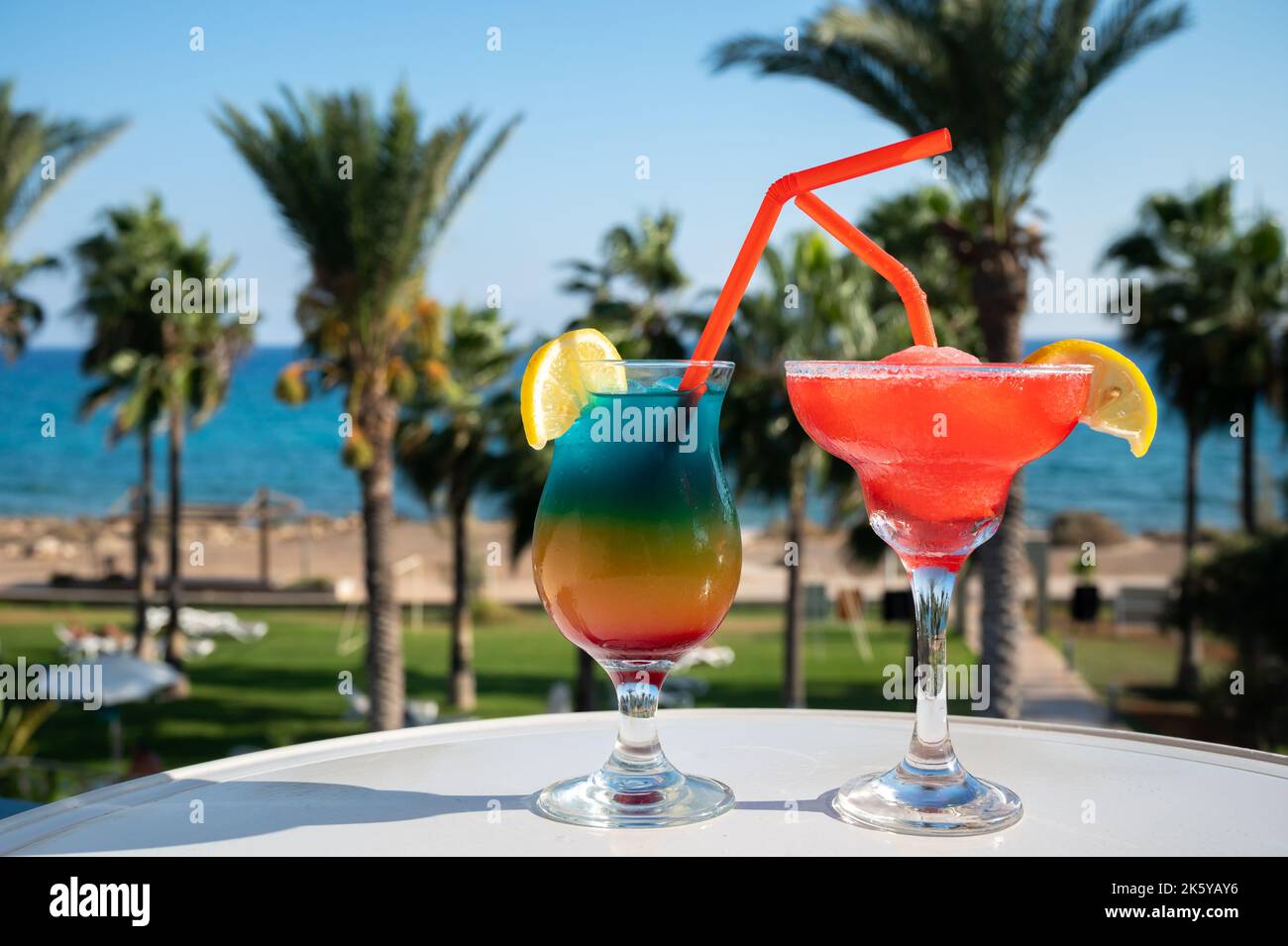 Colourful cold Rainbow Paradise and Strawberry daiquiri cocktails ...