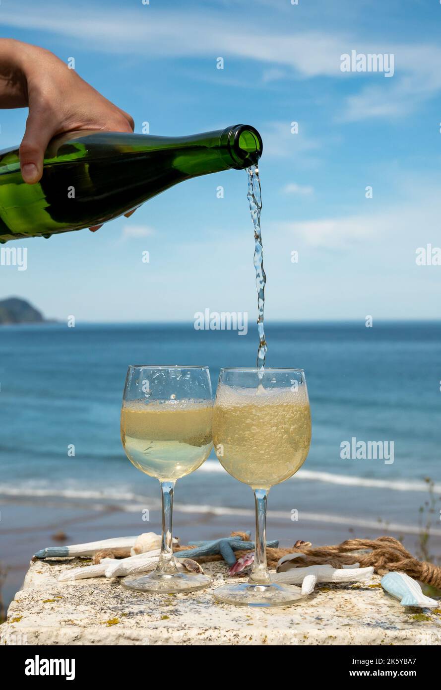 Pouring of txakoli or chacolí slightly sparkling very dry white wine ...