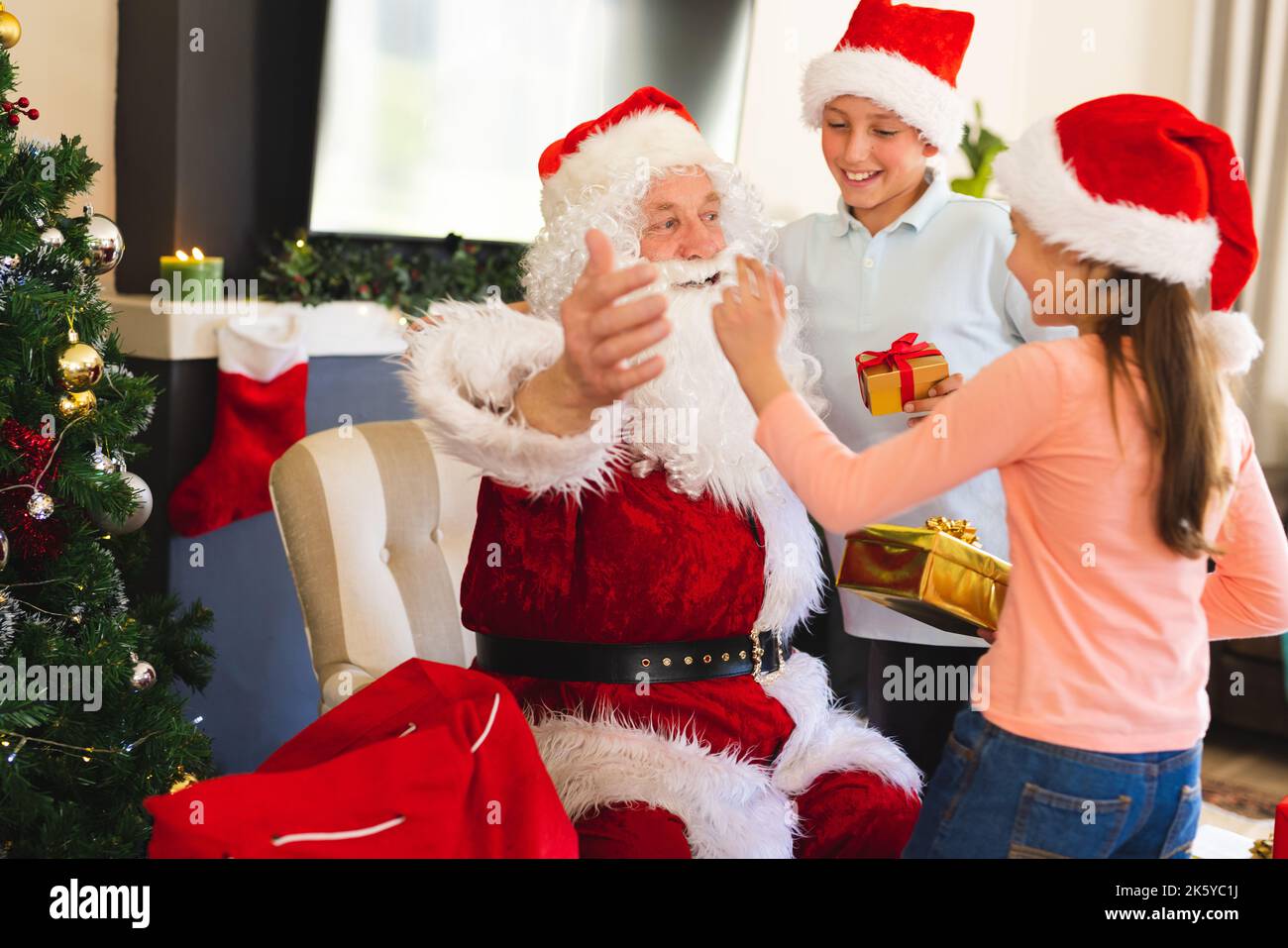Caucasian children with santa claus giving them christmas gifts Stock ...