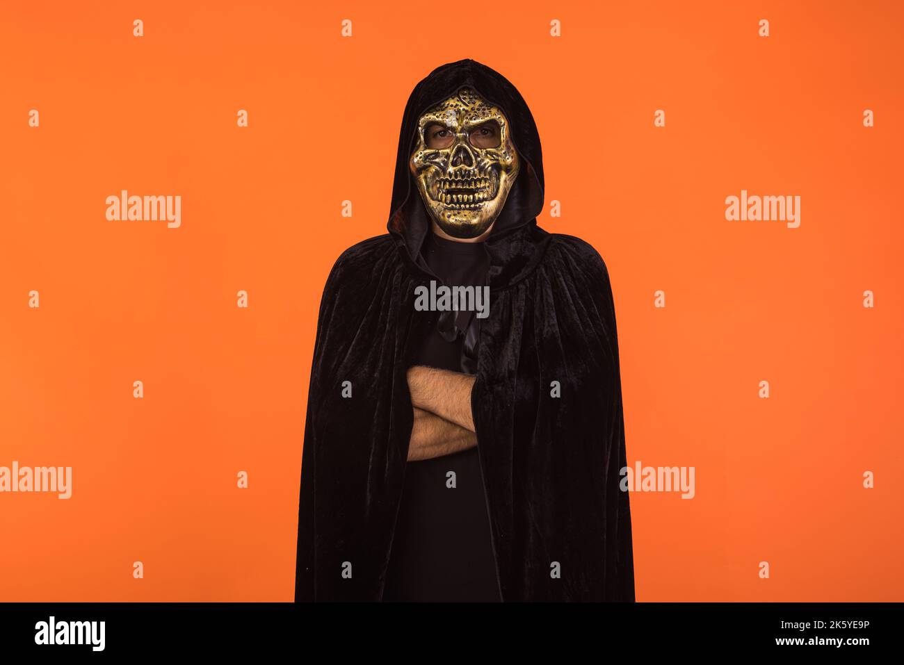 Person with skull mask and black hooded cape, with crossed arms ...