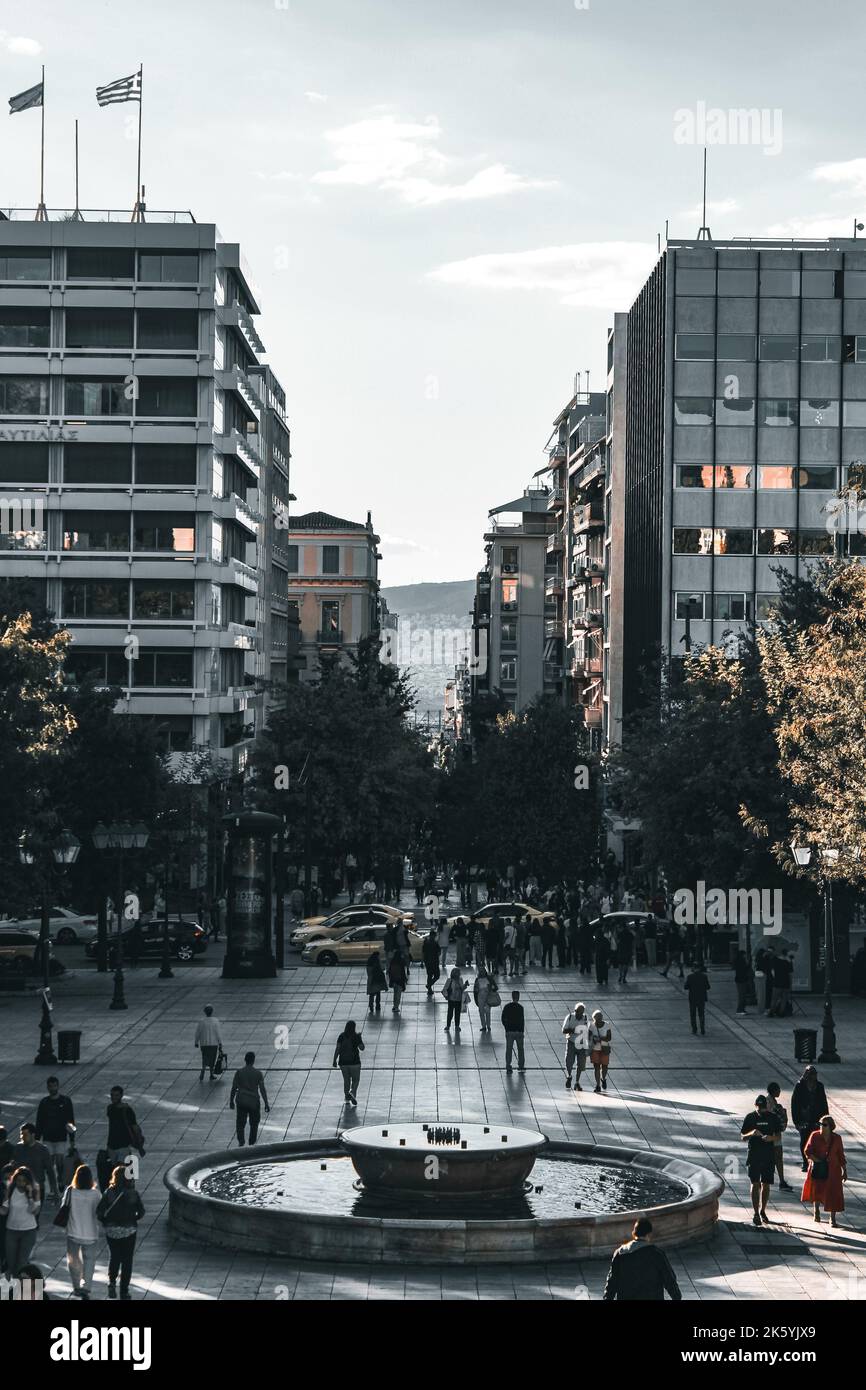 A vertical of people walking in the Syntagma Square with its multi ...