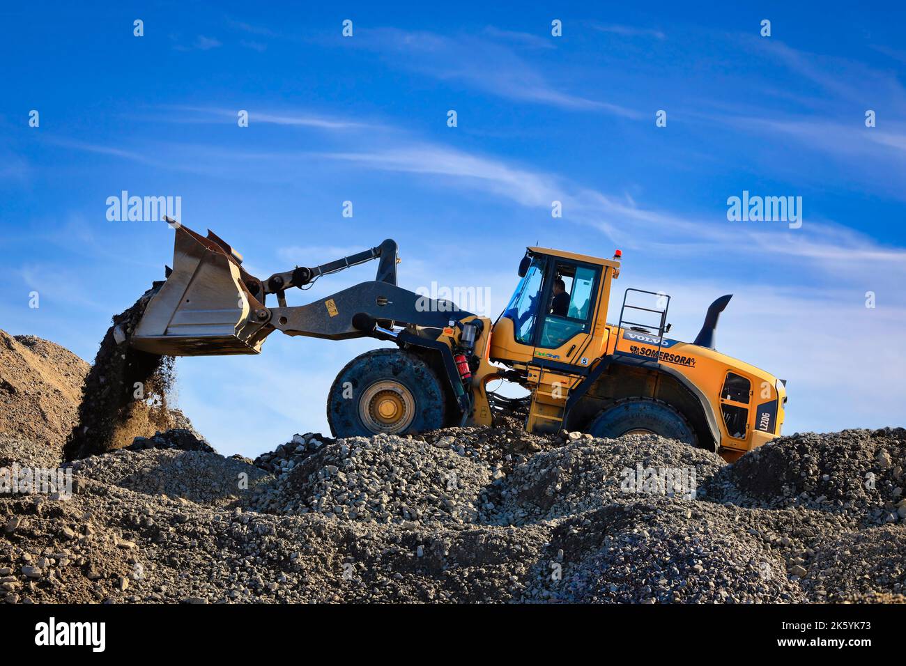 Volvo L220G wheel loader working on top of a mound at construction site ...
