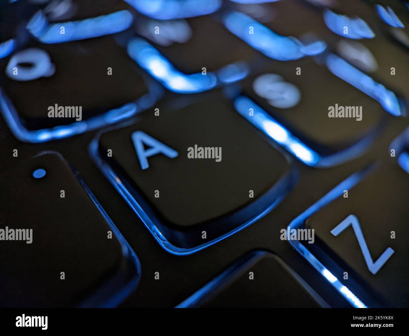 Closeup view of A and Z keys on a black laptop keyboard with glowing ...