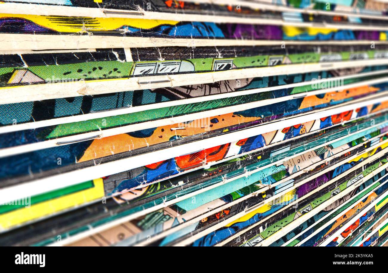 Old faded comic book collection stacked in a pile creates a colorful ...