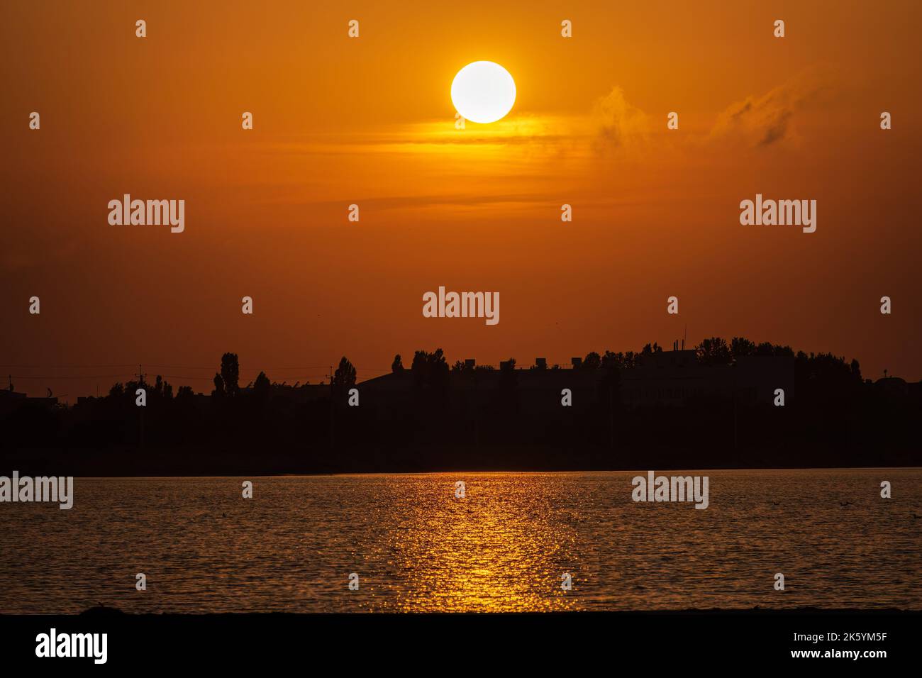 The sun goes down over a lake. Dramatic Sunset Sky Stock Photo - Alamy