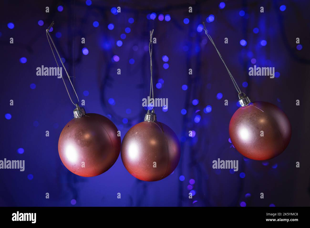 pink christmas balls swinging like a pendulum on a background of blue ...
