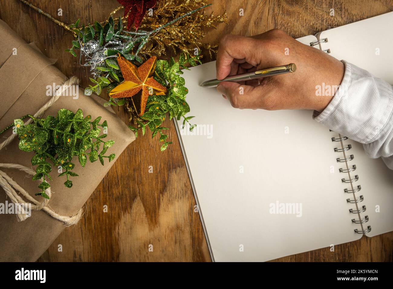 Christmas background of a man's hand writing a message in a notebook ...