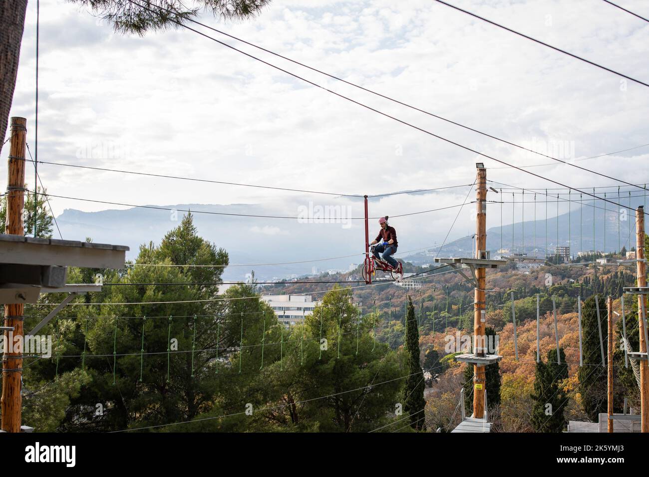 A man is resting in a rope amusement park. Front view Stock Photo - Alamy