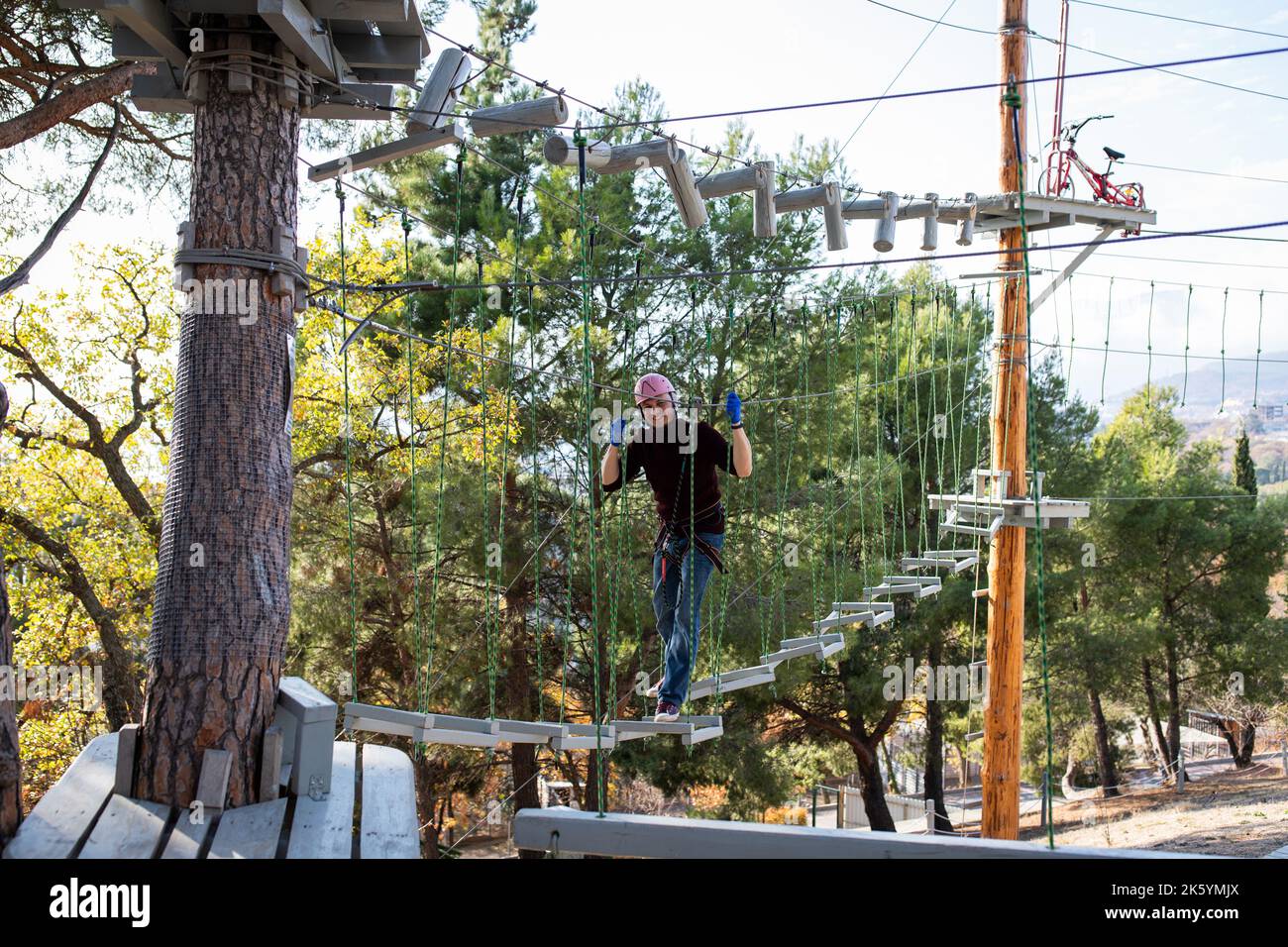 A man is resting in a rope amusement park. Front view Stock Photo - Alamy