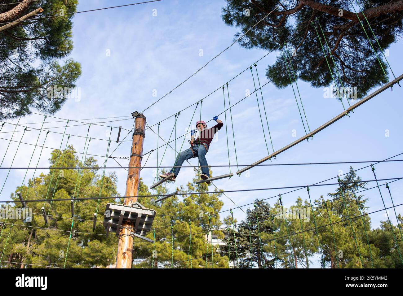 A man is resting in a rope amusement park. Front view Stock Photo - Alamy