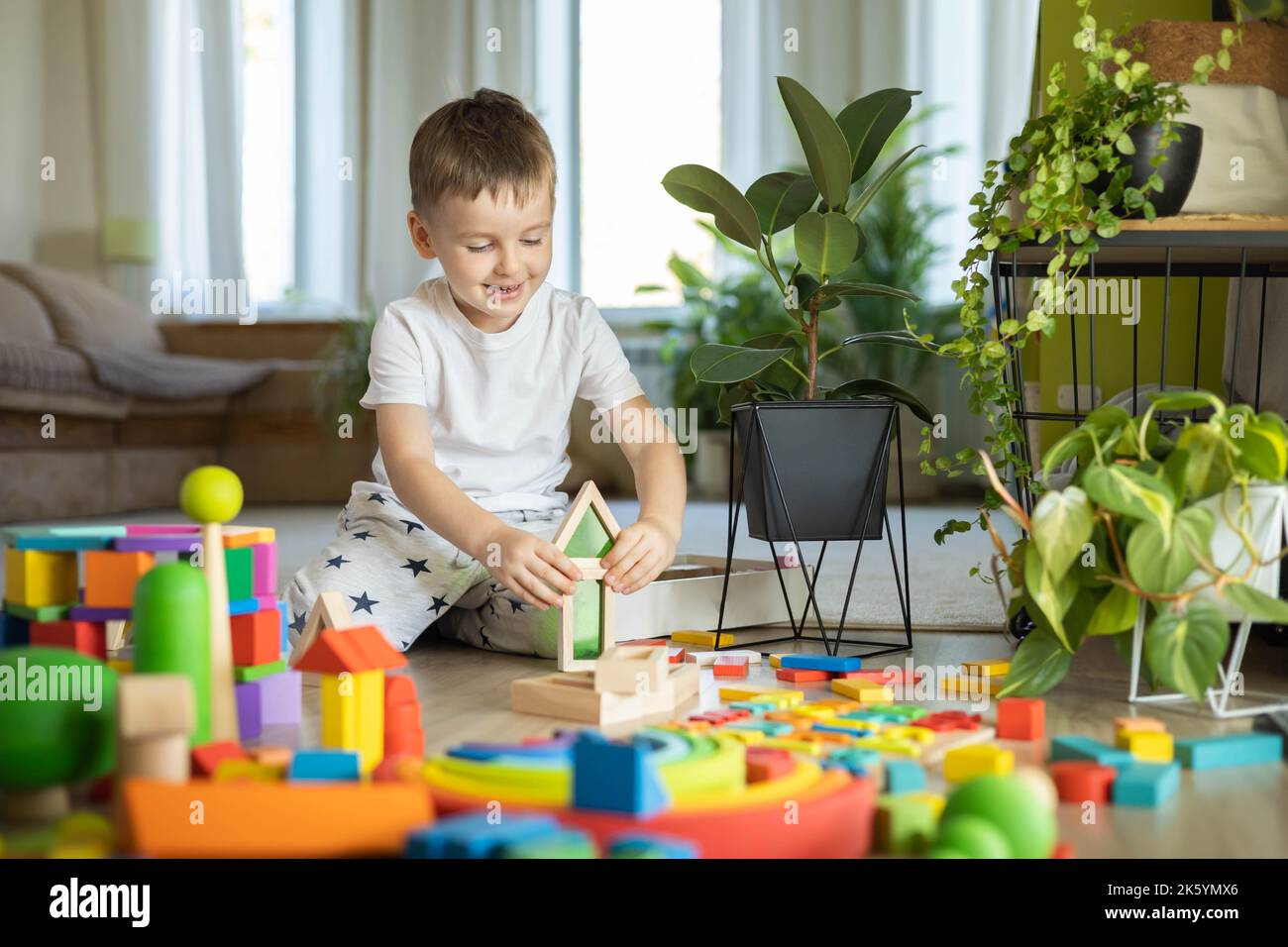 Confident male kid building fortress tower architecture and forest with ...