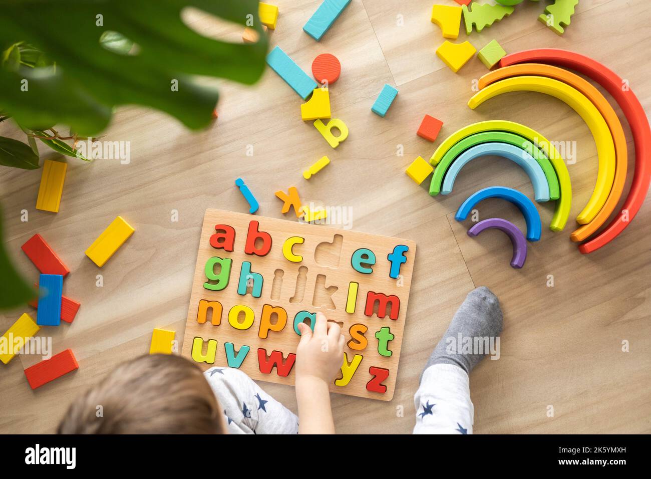 Male kid playing with wooden eco friendly alphabet letters board on ...