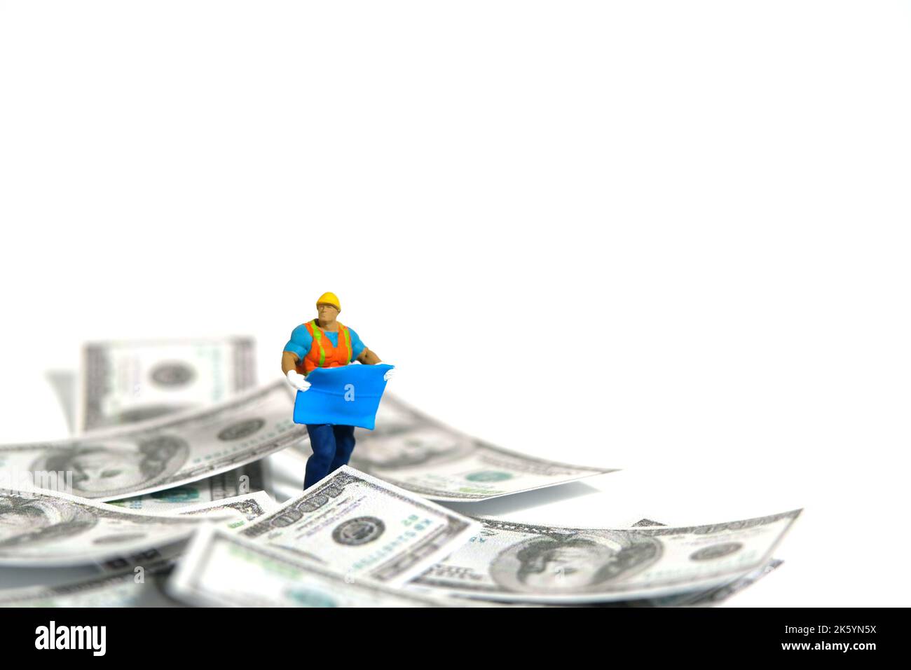 Miniature people toy figure photography. Project budget concept. A ...