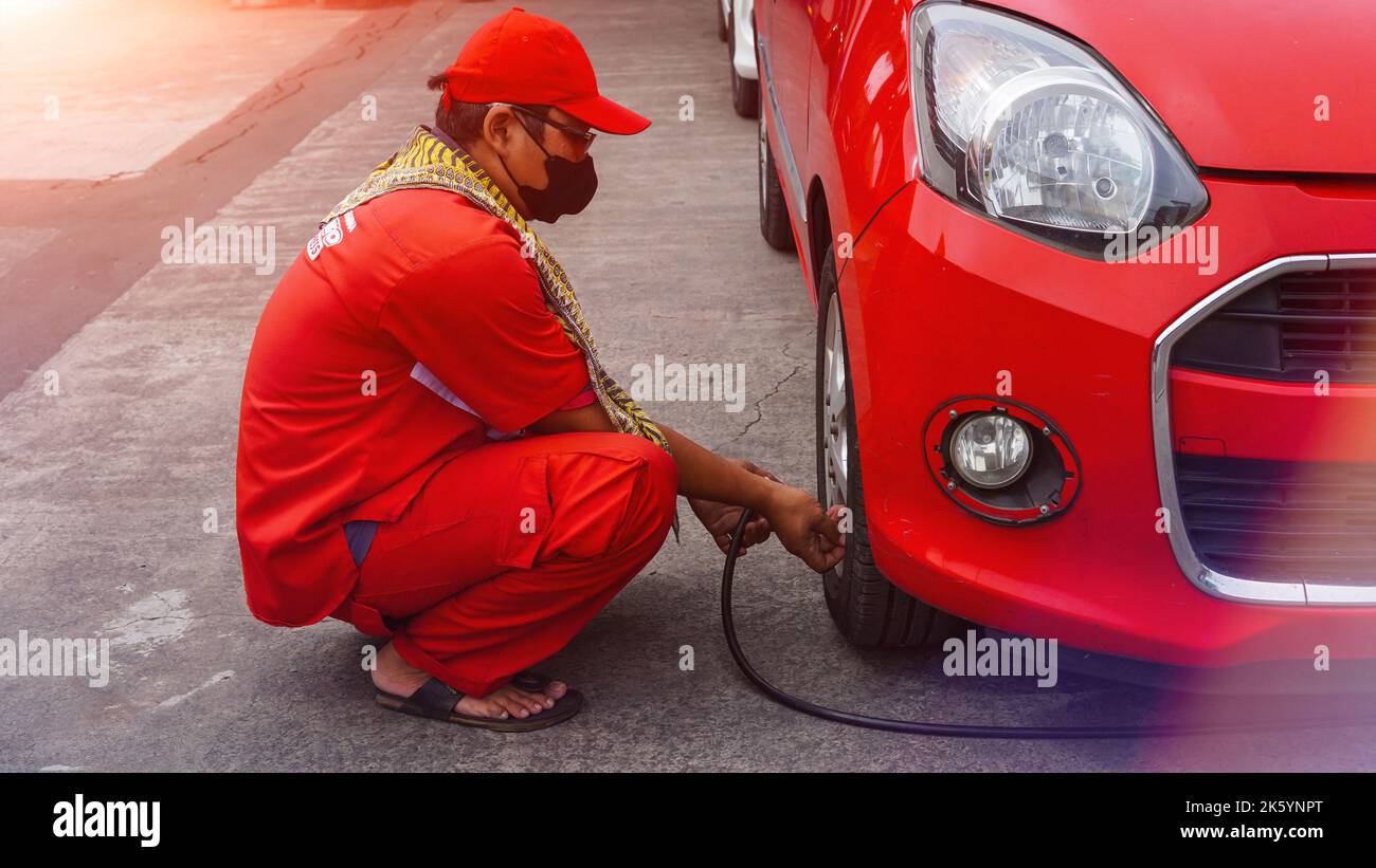 Jakarta, Indonesia 10 October 2022 : Close up mechanic inflating tire ...