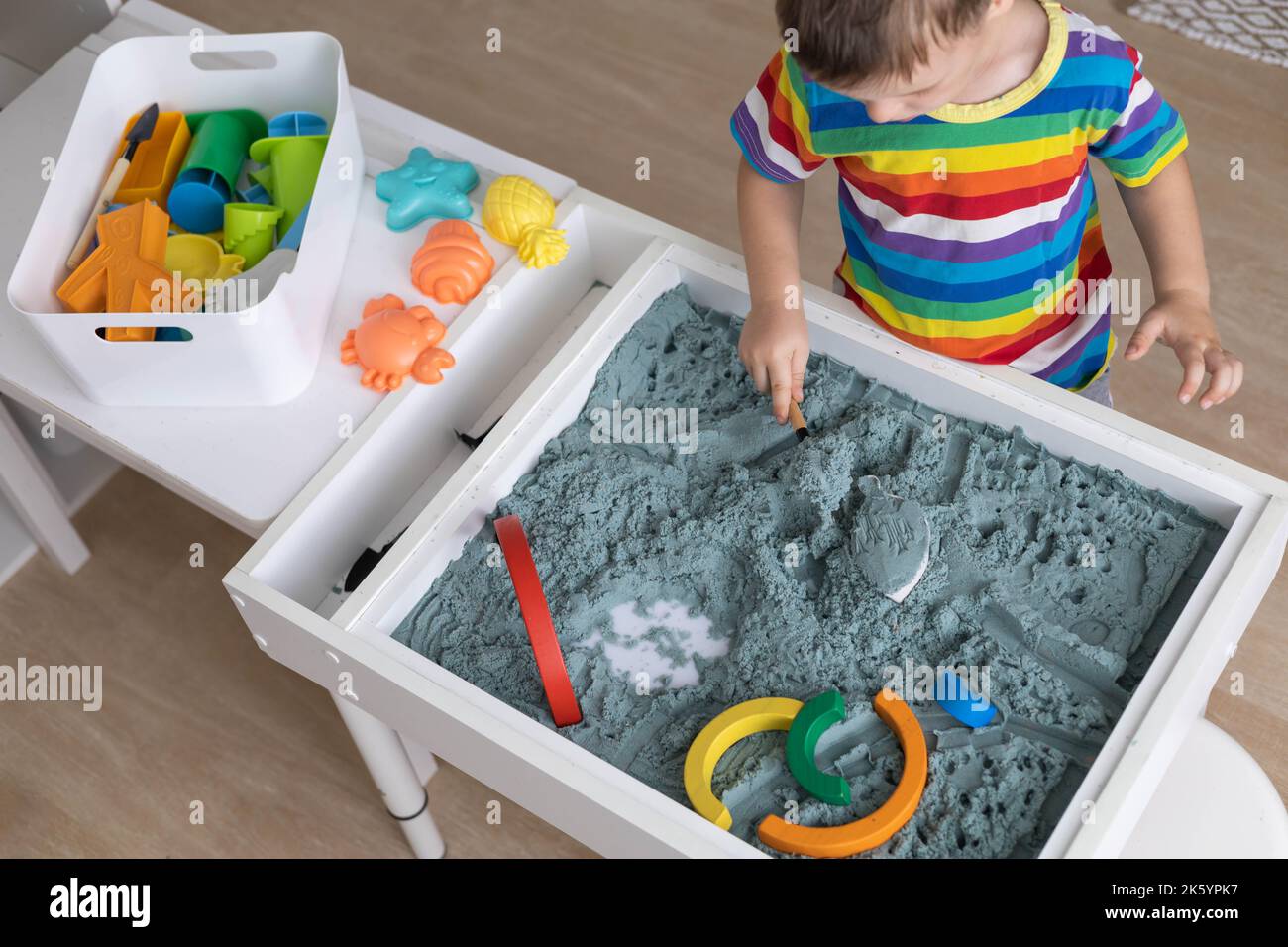 Overjoyed male kid playing kinetic sand early development education ...