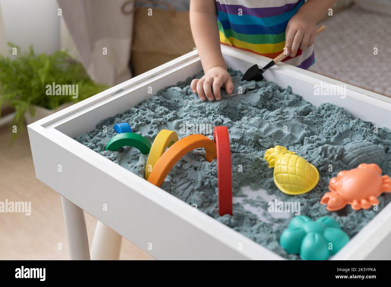 Overjoyed male kid playing kinetic sand early development education ...