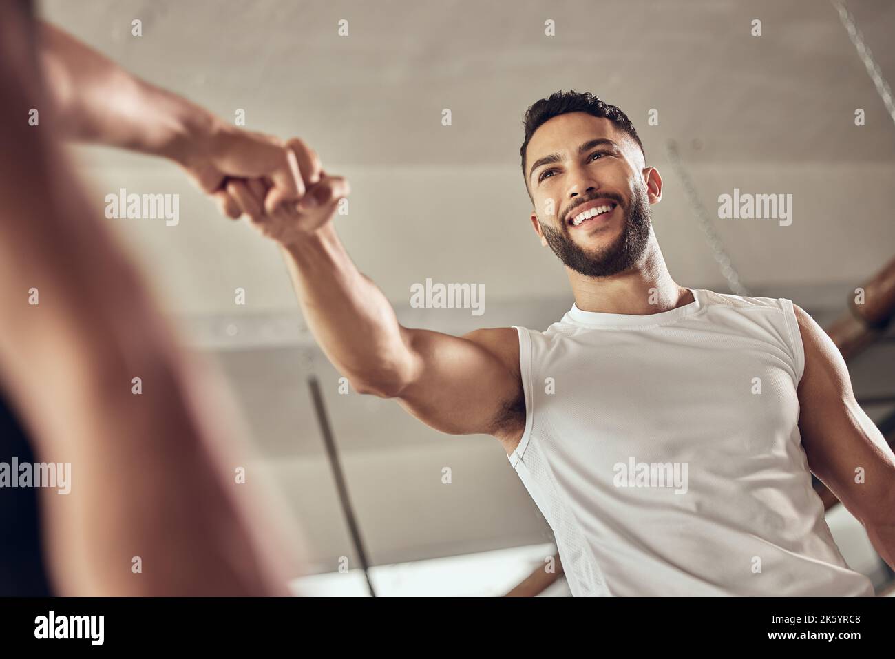 Strong bodybuilder giving fist bump to partner. Two athletes motivate ...