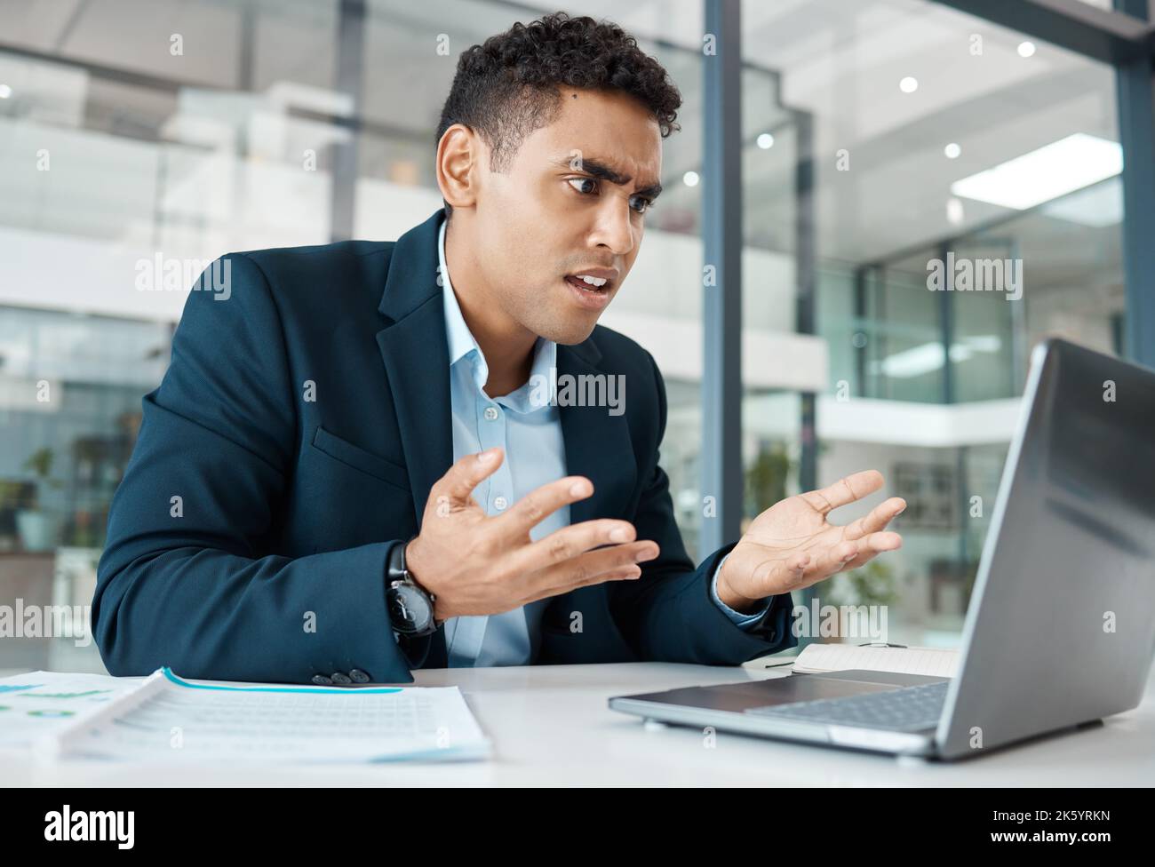 Young confused mixed race businessman making a hand gesture while upset ...