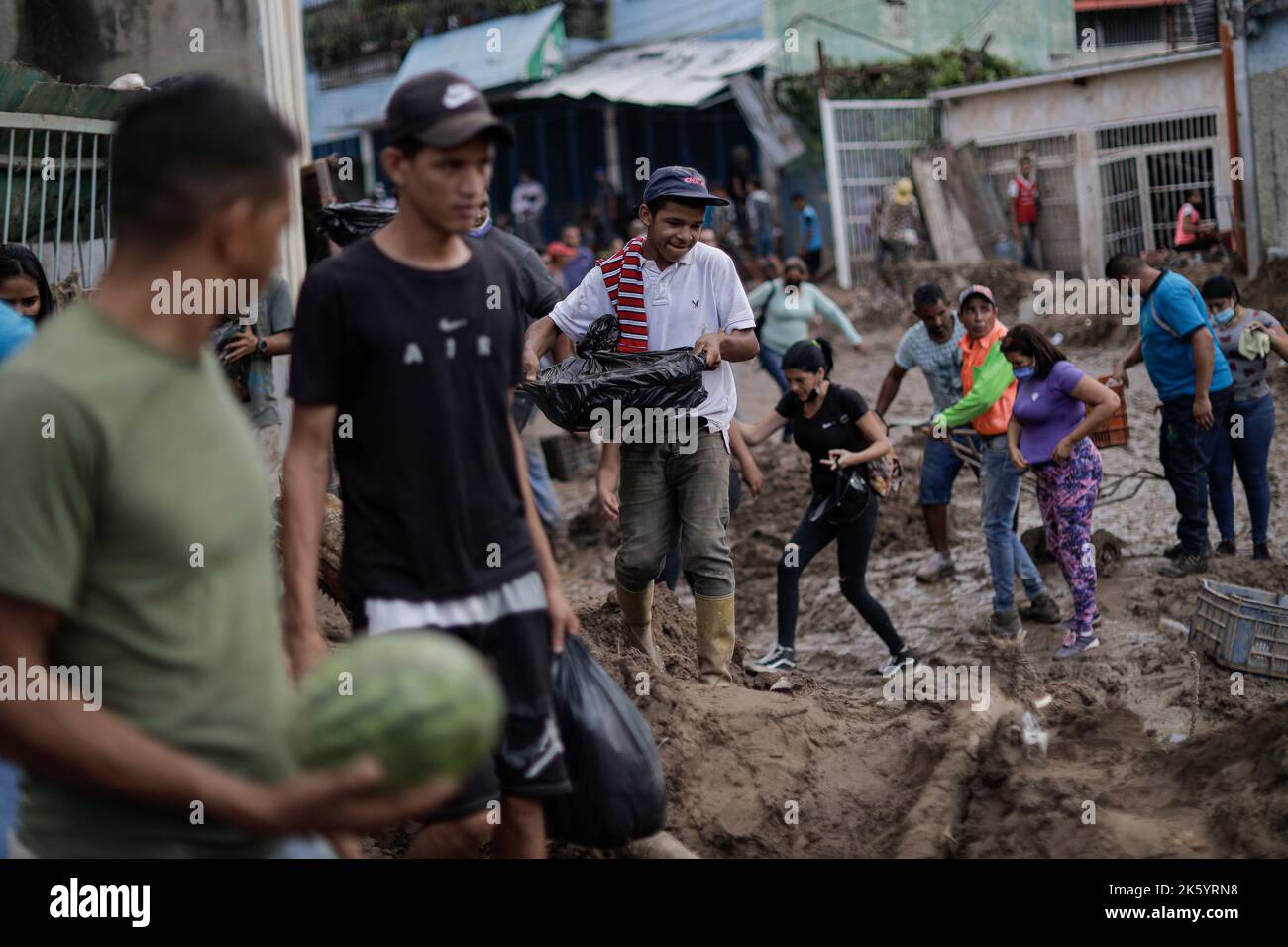 Las Tejerias, Venezuela. 10th Oct, 2022. People walk over mud after ...