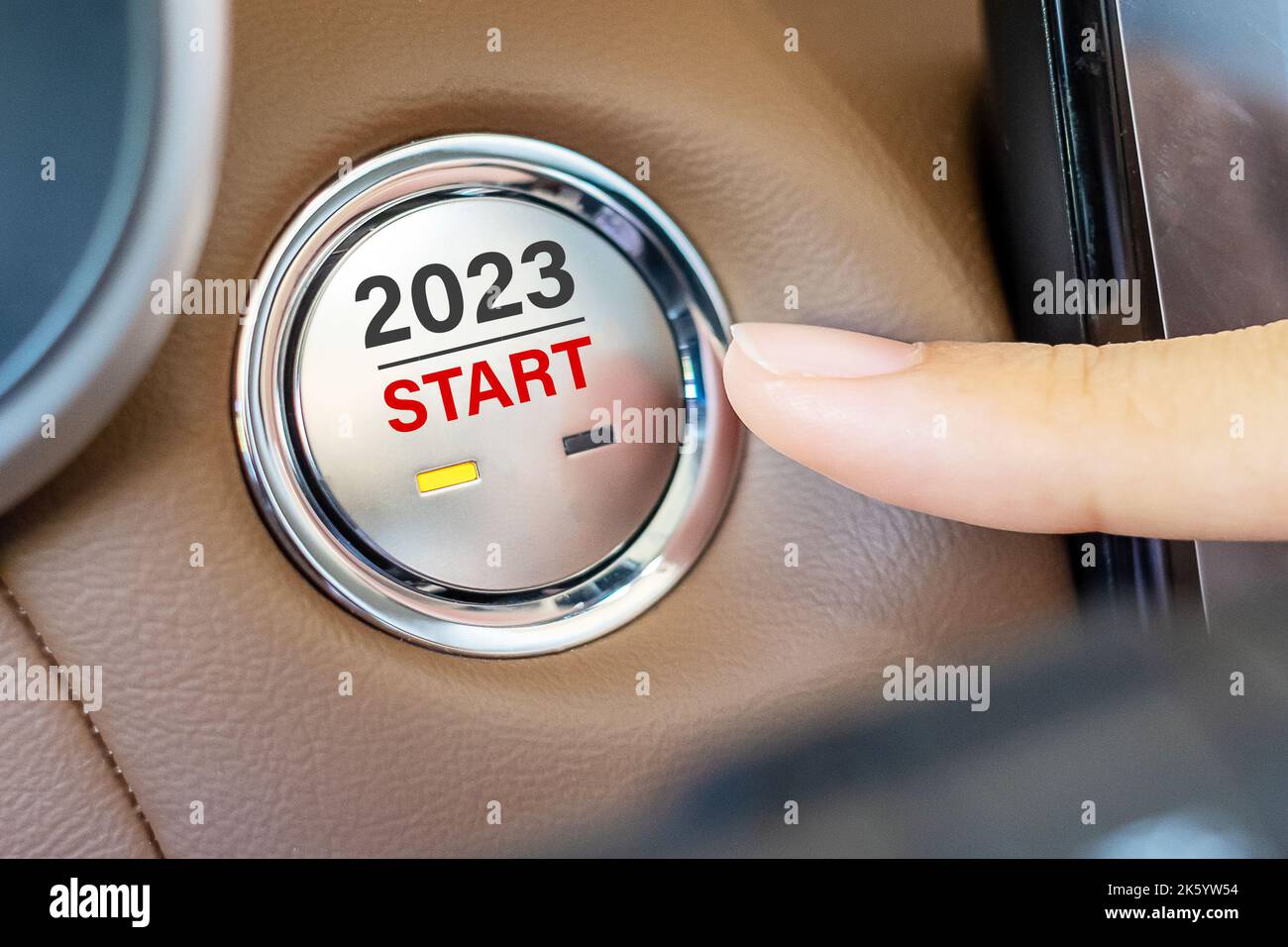 Finger press a car ignition button with 2023 START text inside ...