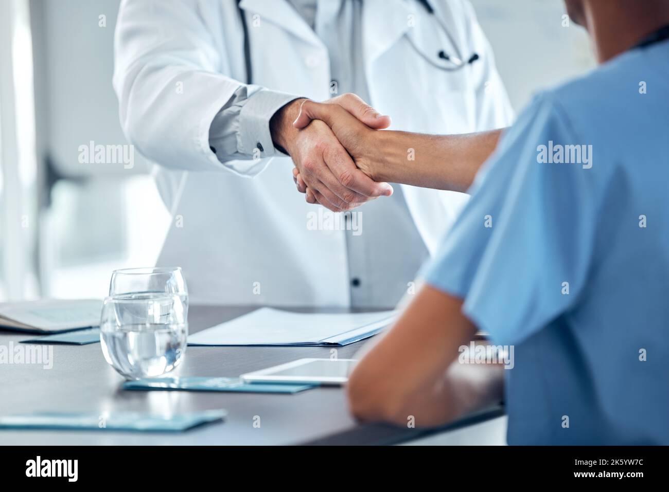 Doctor handshake, congratulations and nurse at office desk consulting ...