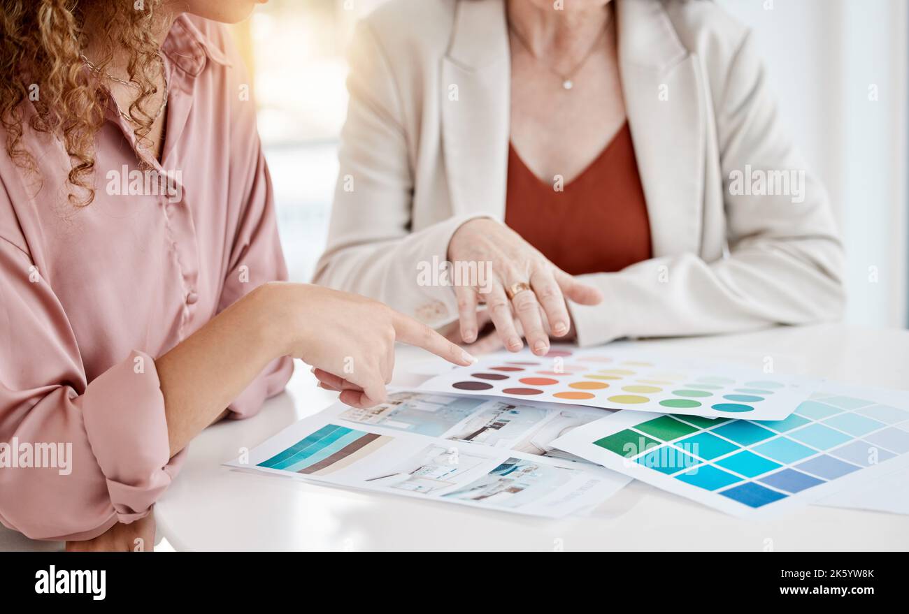 Closeup of two businesspeople looking at colour swatches while in a ...