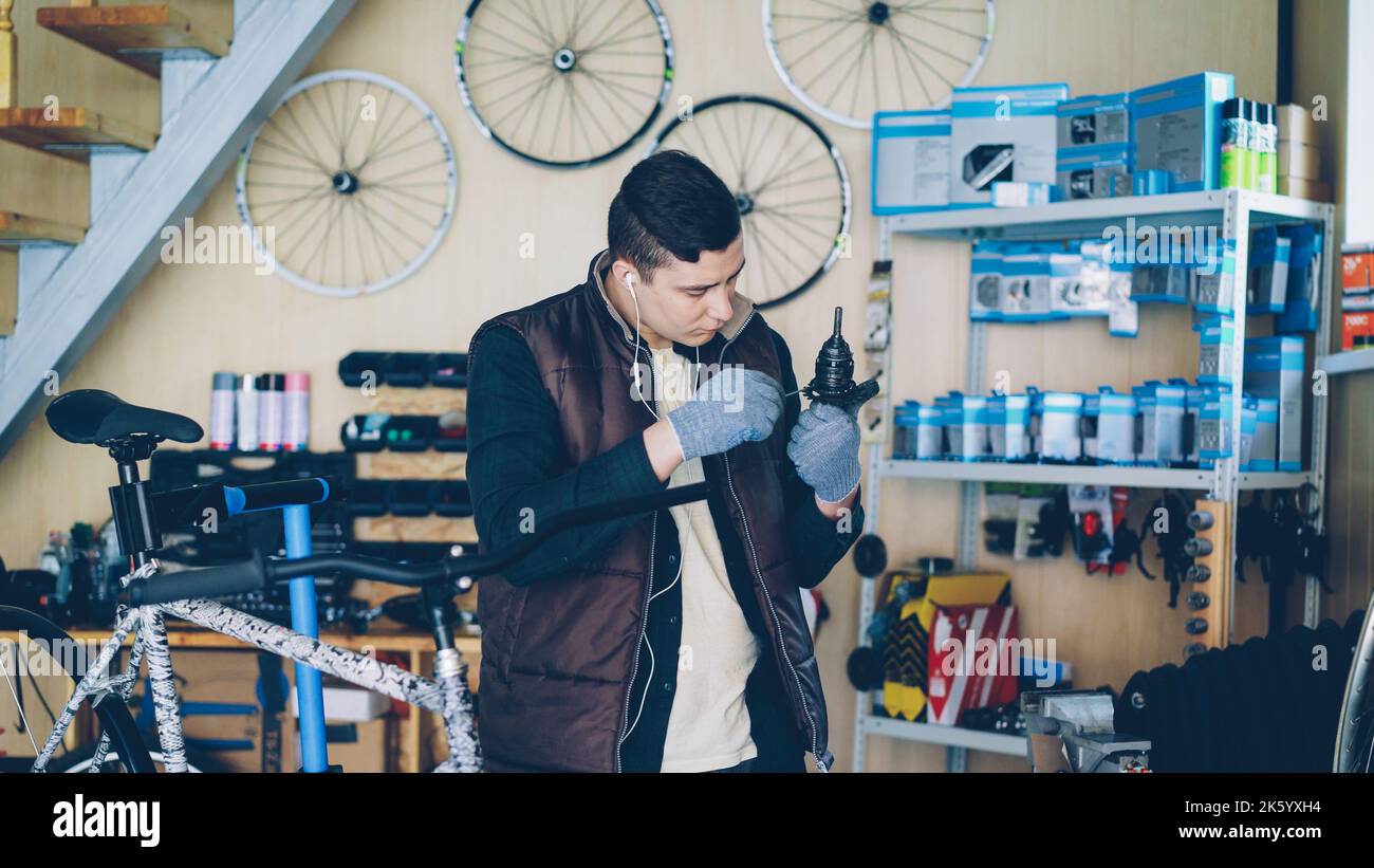 Concentrated repairman is greasing mechanism while repairing bicycle in ...