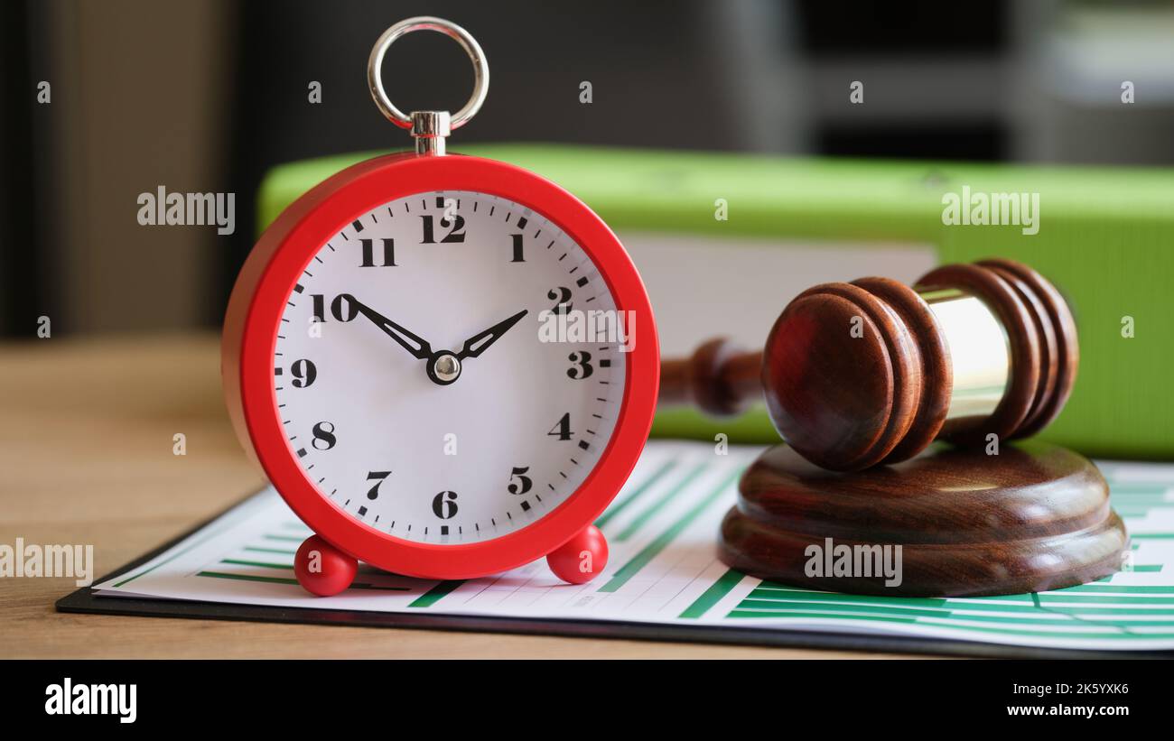 Judges hammer with red alarm clock on clipboard Stock Photo - Alamy