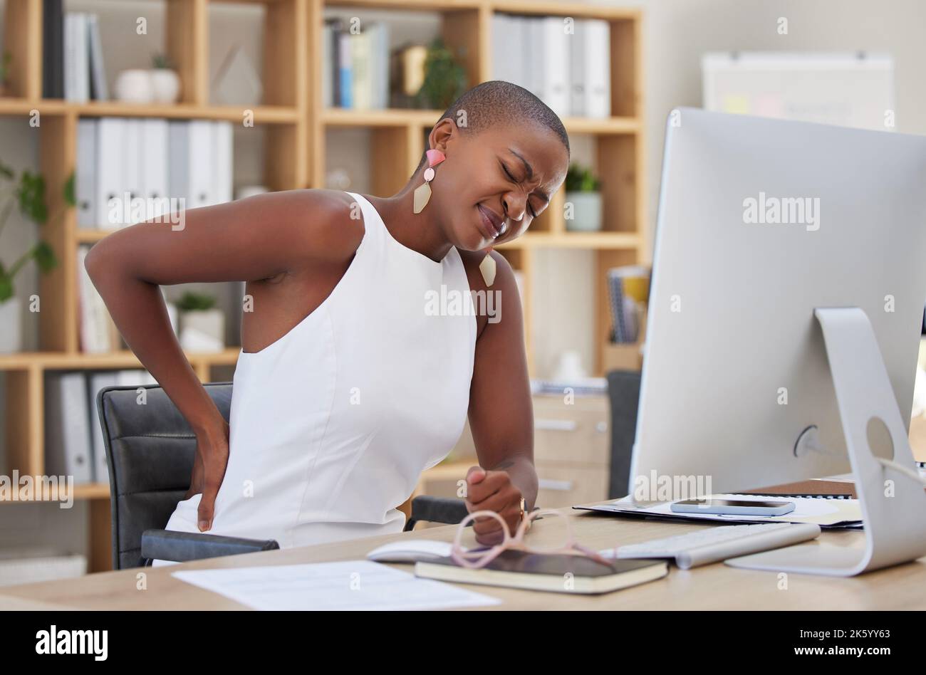 Young african american businesswoman suffering from back pain while ...