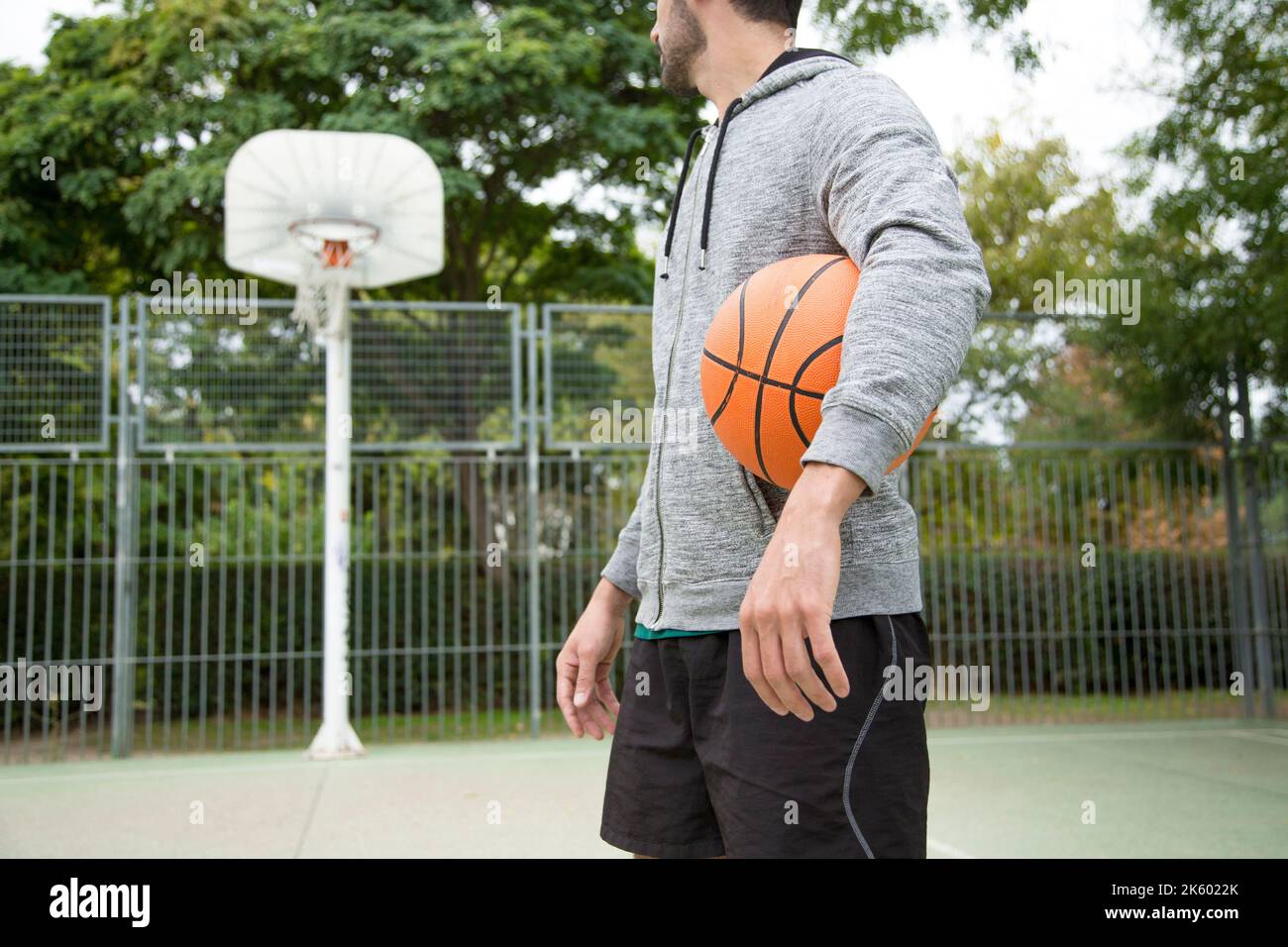 Cropped photo of an unrecognizable sportive man with a basketball ball ...