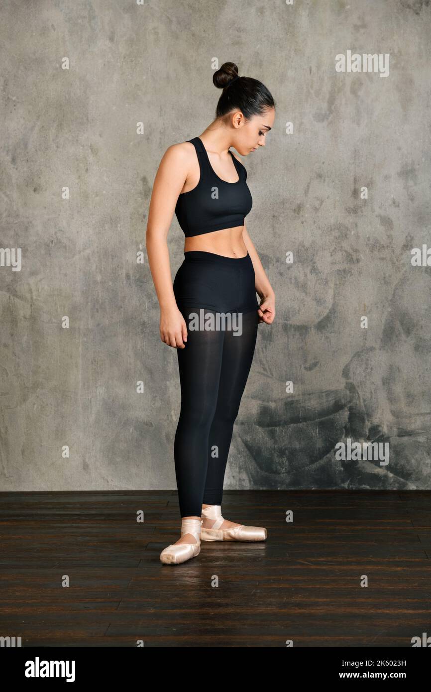 Attractive young teenage ballerina standing in a studio in ballet ...