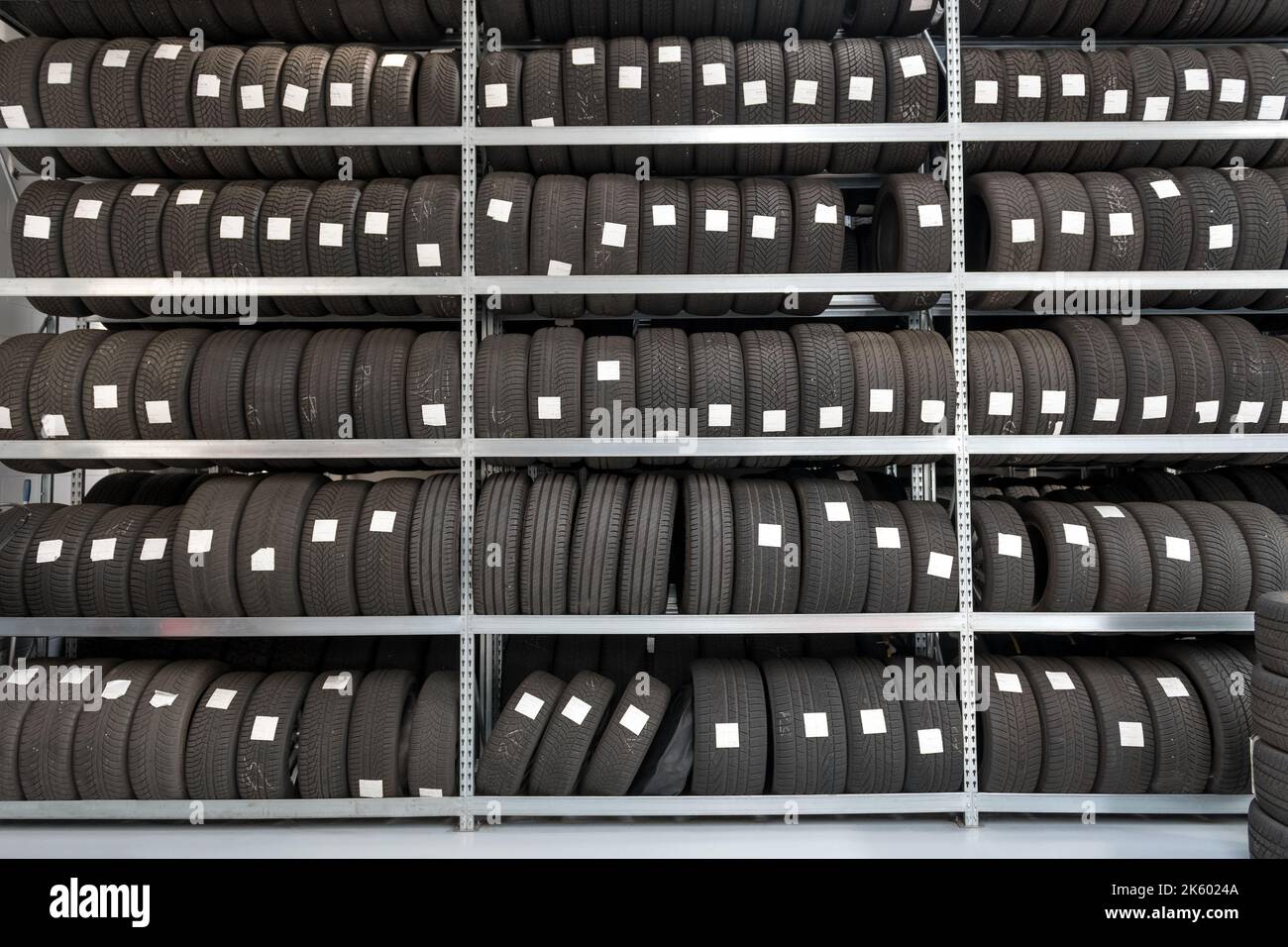 Tires storage inside a tire shop, front view Stock Photo - Alamy