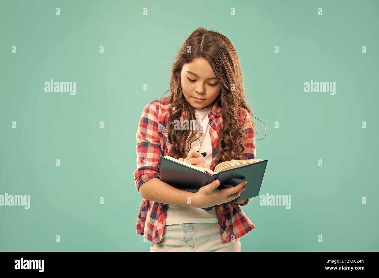 serious teen girl make notes on blue background, education Stock Photo ...