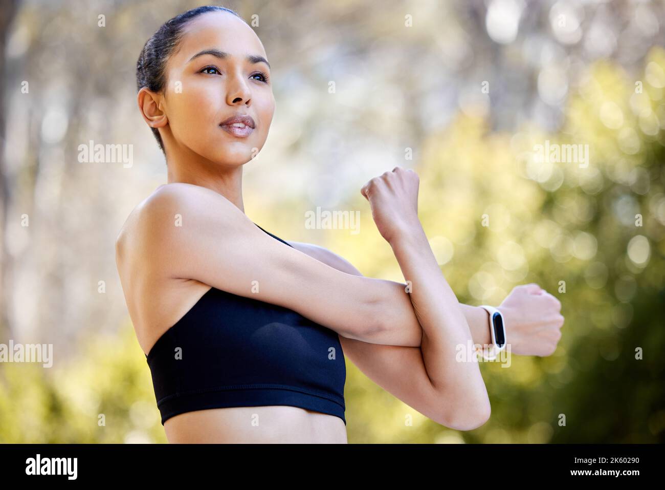 One fit young mixed race woman stretching arms for warmup to prevent ...