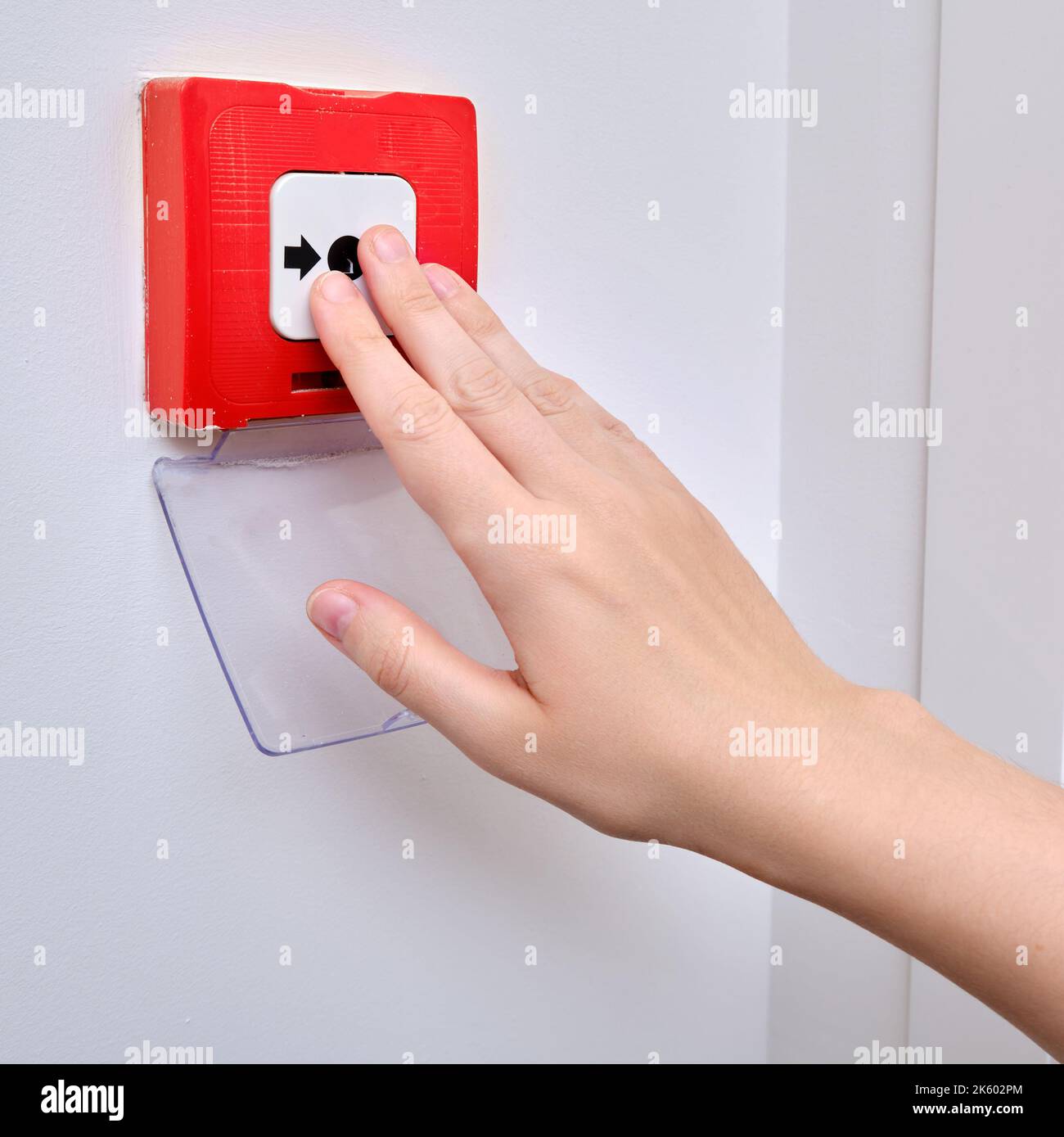 Woman reaches for the fire alarm, hand turns on the call button for ...
