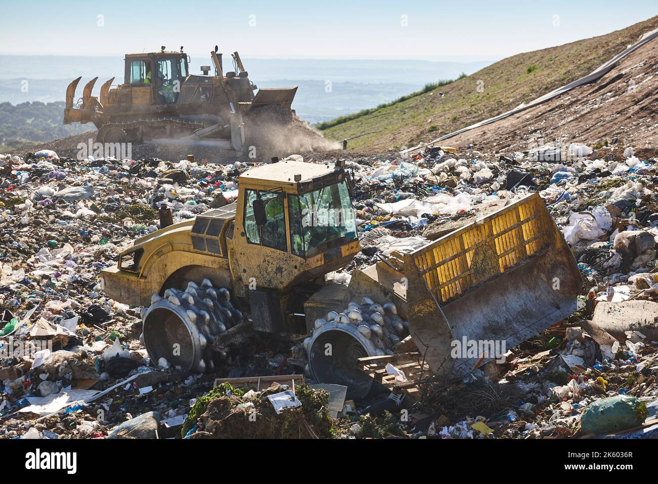 Heavy machinery shredding garbage in an open air landfill. Waste Stock ...