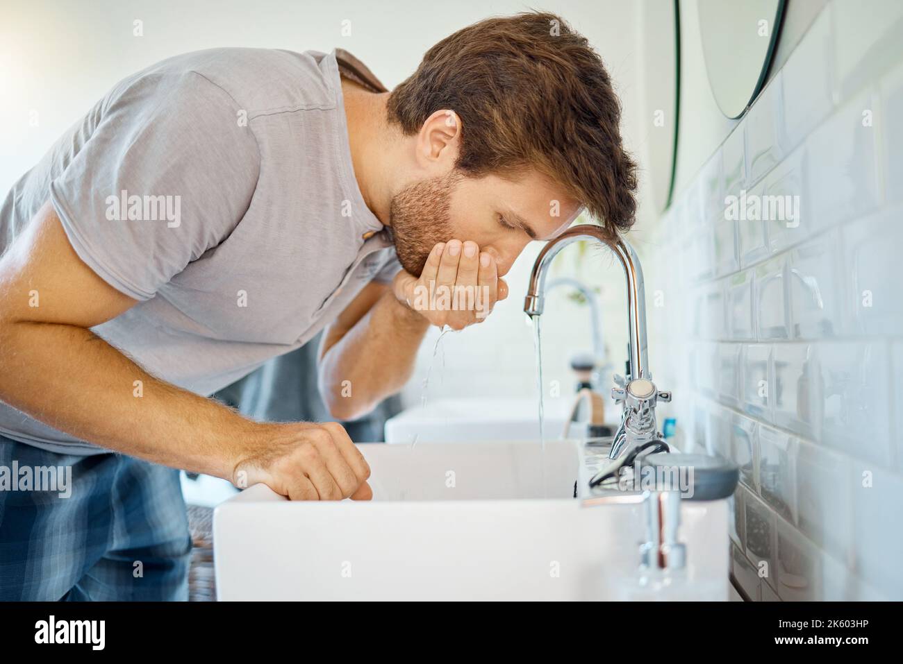 One handsome man rinsing his mouth in a bathroom at home. Caucasian ...