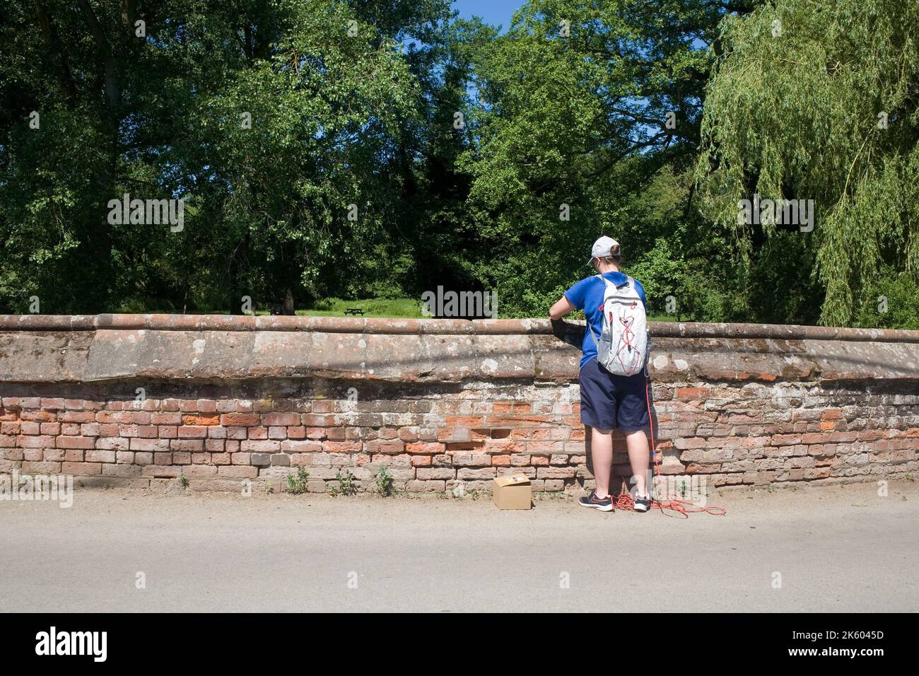 research worker on bridge collecting water sample from river Brett in ...