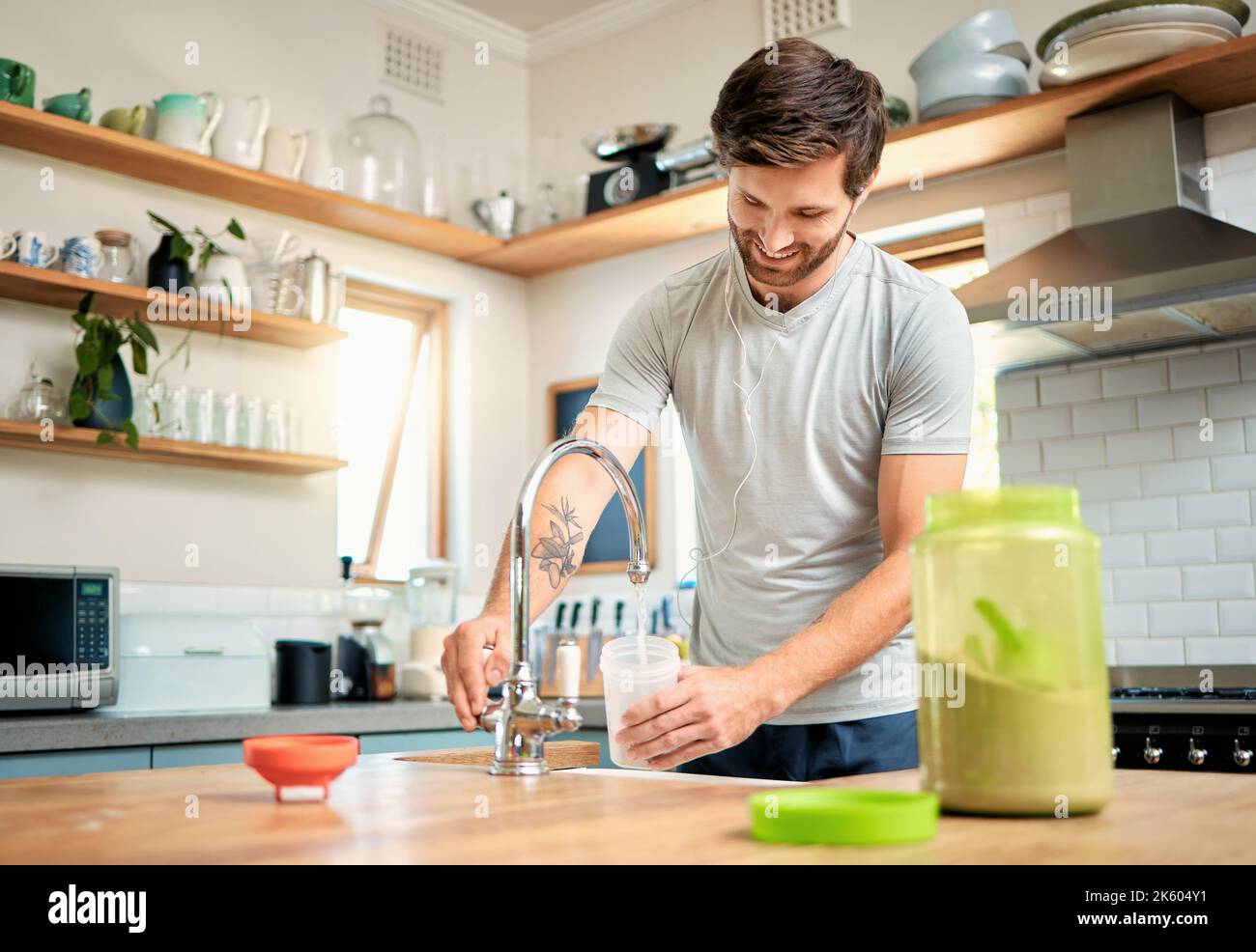 One fit young caucasian man pouring water into a bottle for chocolate ...