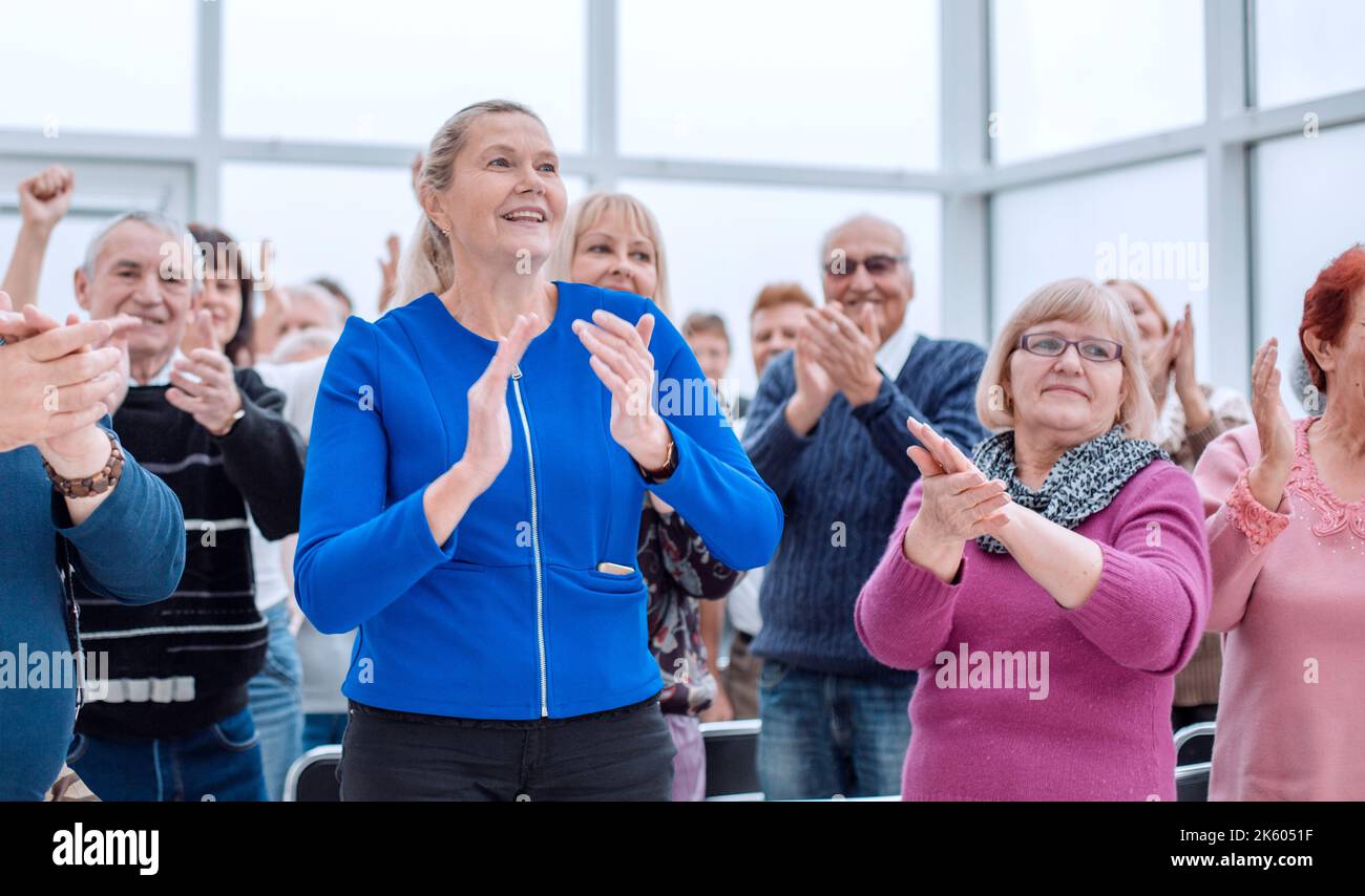 a group of elderly people are sitting in a circle clapping their Stock ...