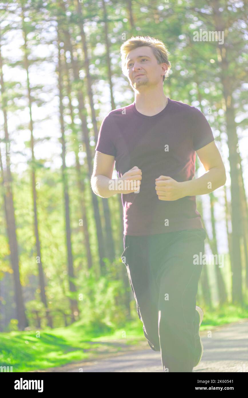 Running man jogging in city park at beautiful summer day. Sport fitness ...