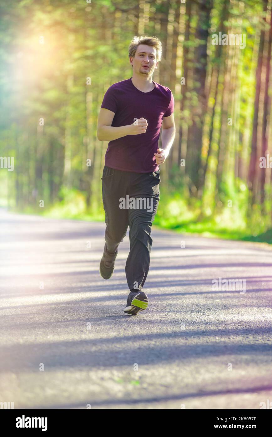 Running man jogging in city park at beautiful summer day. Sport fitness ...