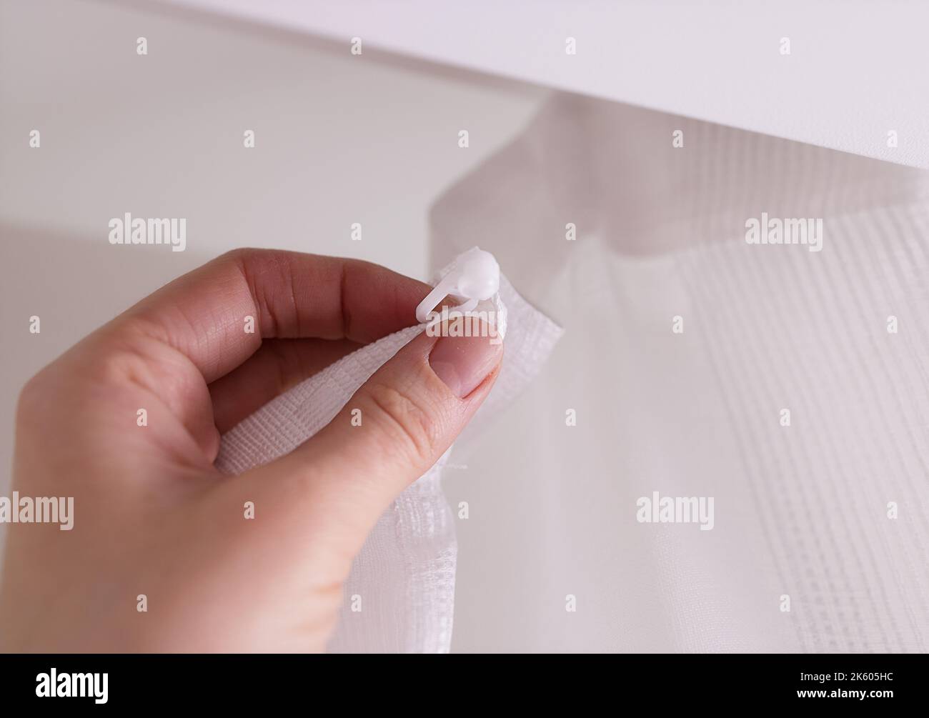 close-up, woman's hands dress the curtain on the window. Housework ...