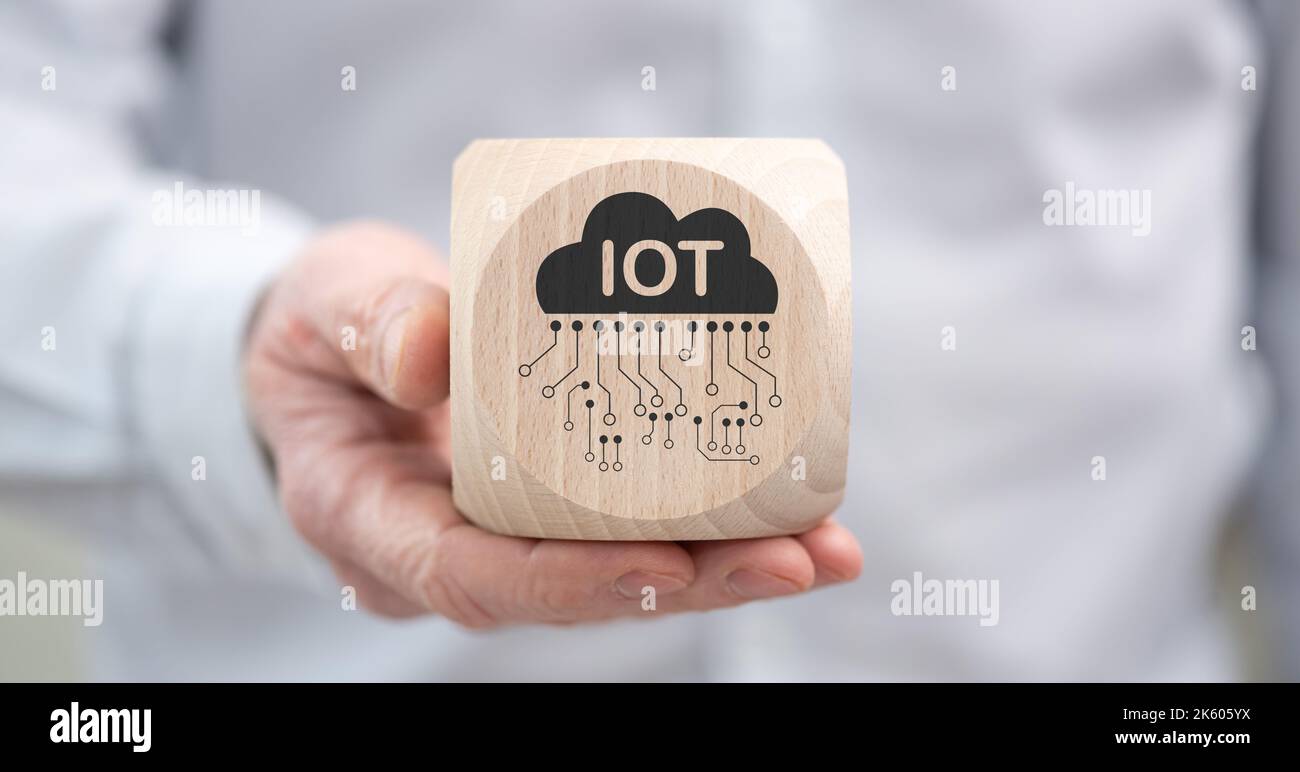Hand holding a wooden cube with symbol of iot concept Stock Photo - Alamy