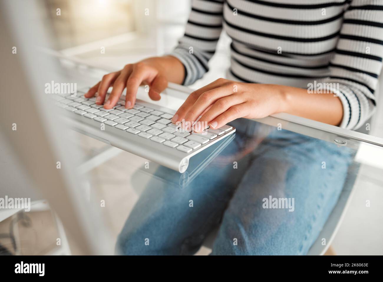 Businessperson typing on a keyboard working on a desktop computer while ...